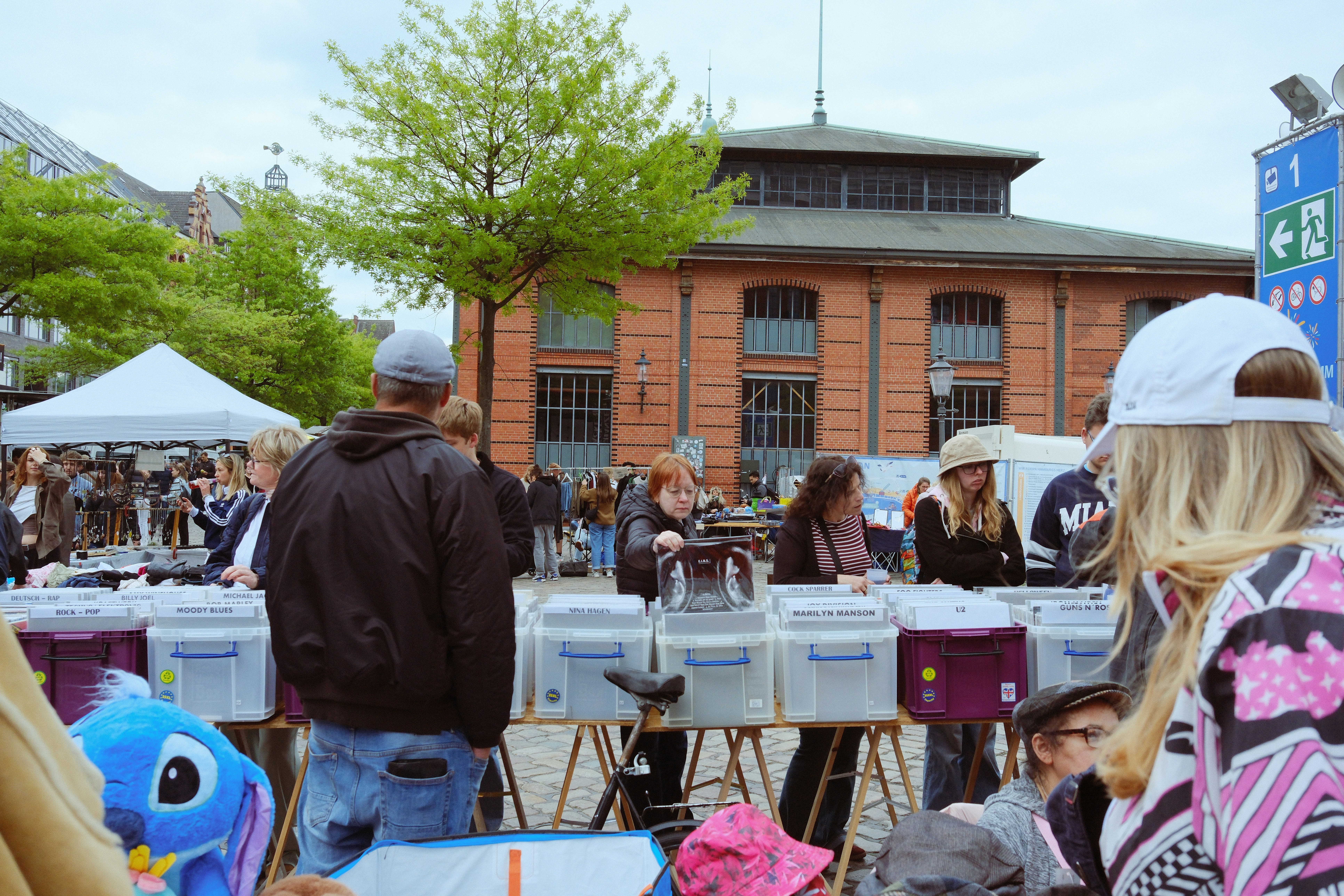 Marketplace of Boxes: A Busy Outdoor Auction in Brick Courtyard