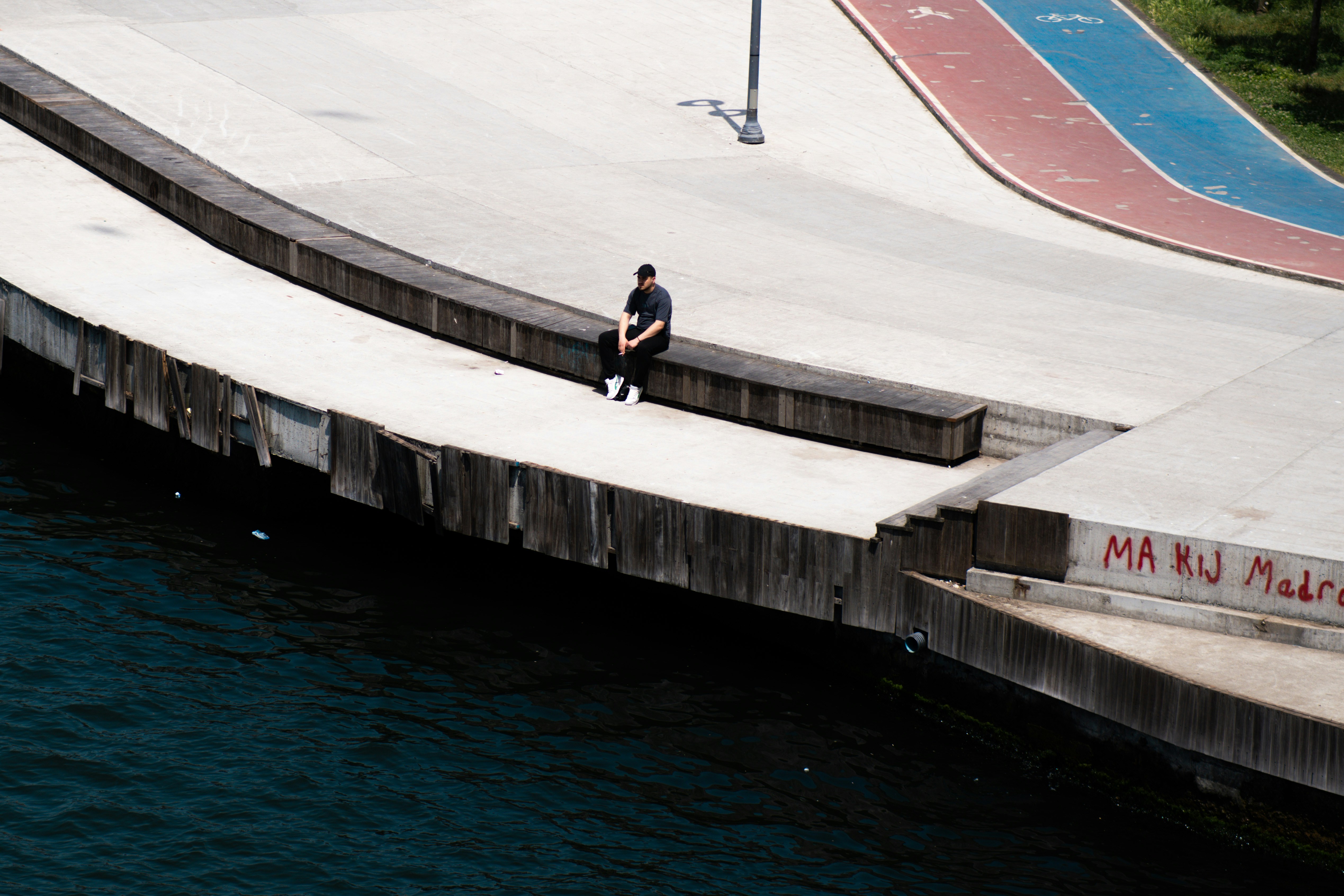 Lone figure on the curved waterfront promenade
