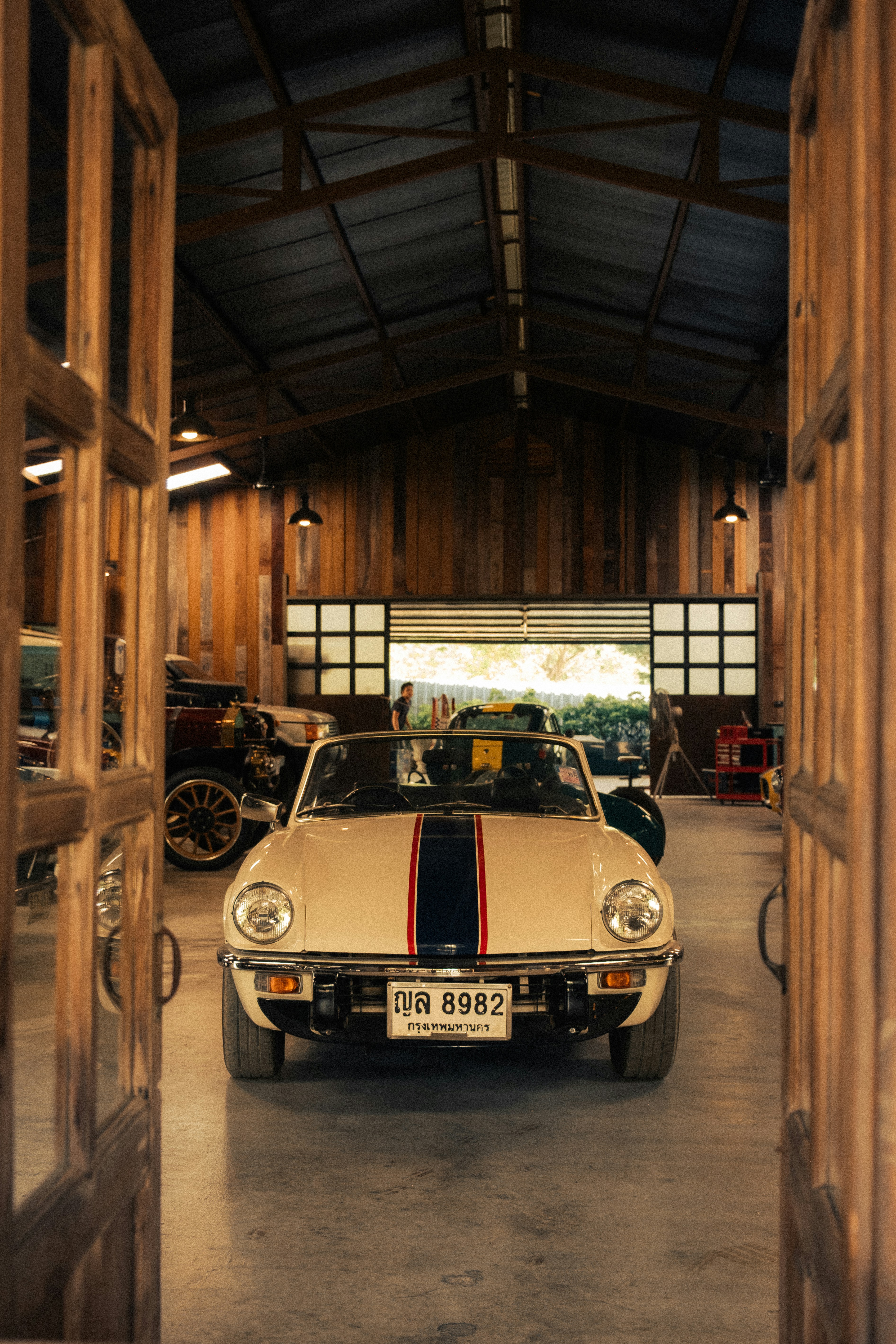Centerstage Classic: A Vintage Roadster Inside a Rustic Workshop