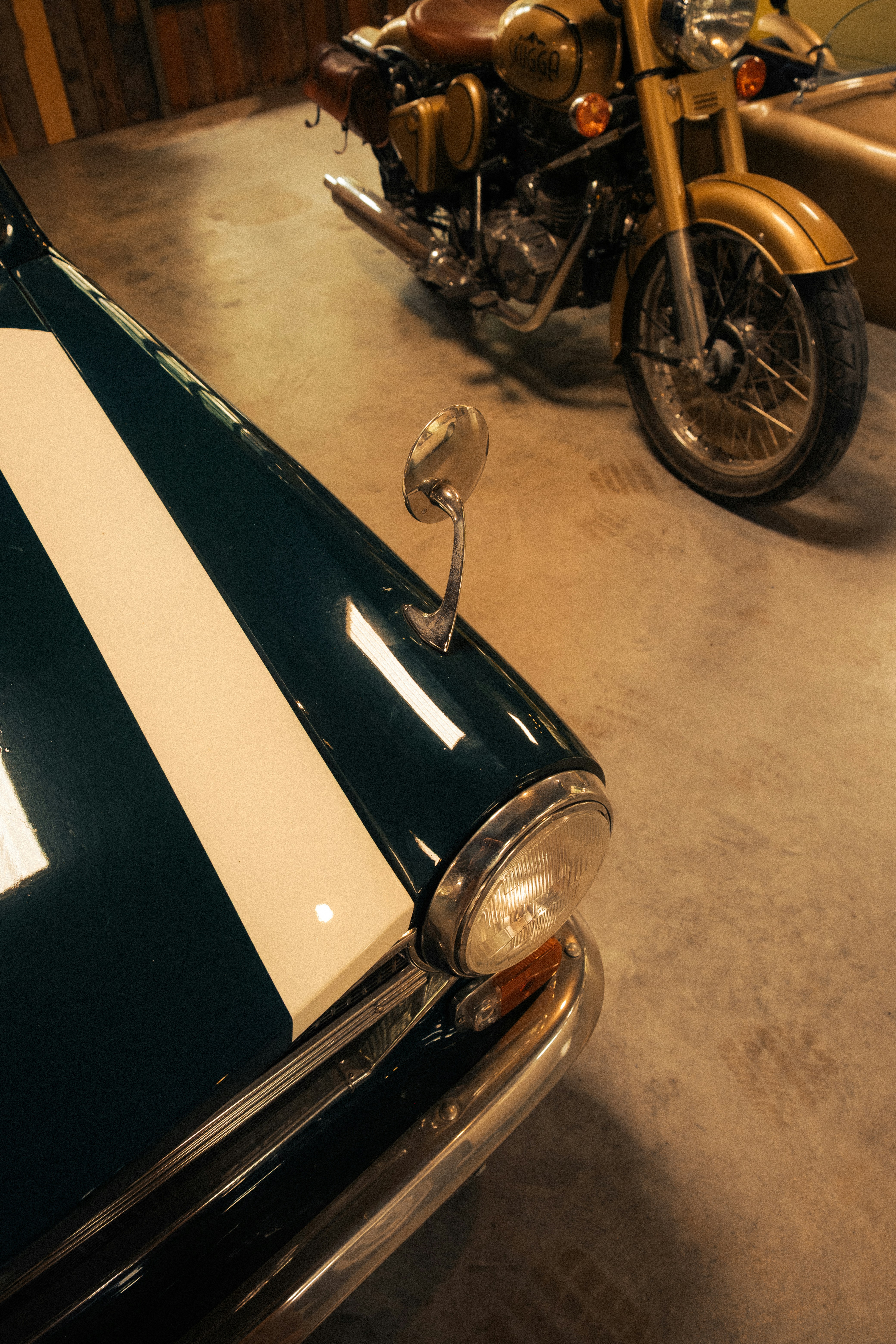 Close-Up of a Vintage Green Car Hood with White Stripe in an Indoor Garage