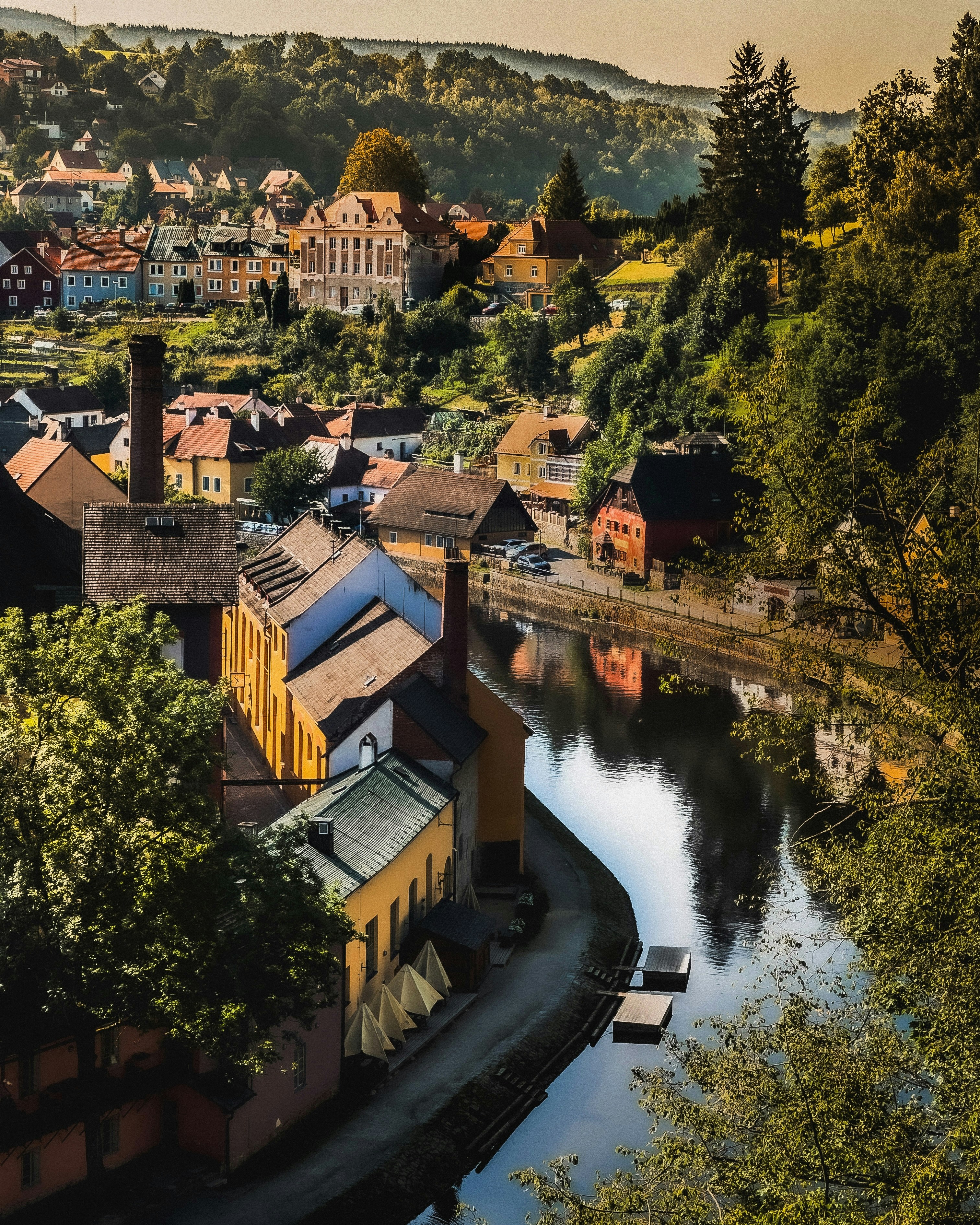 Quaint riverside village with sunlit roofs and winding waterway