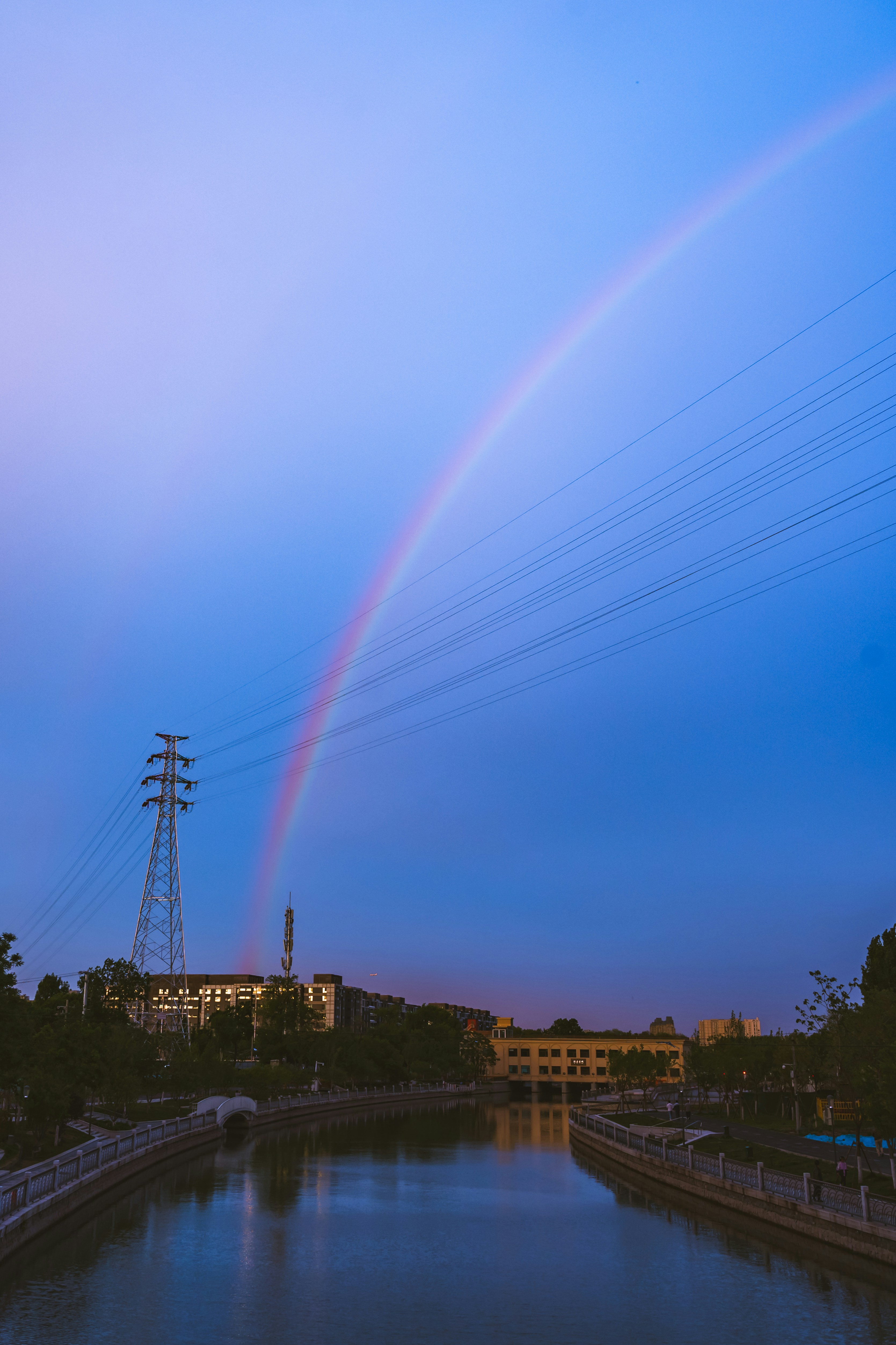 Double Arc: City Canal Beneath a Gentle Rainbow