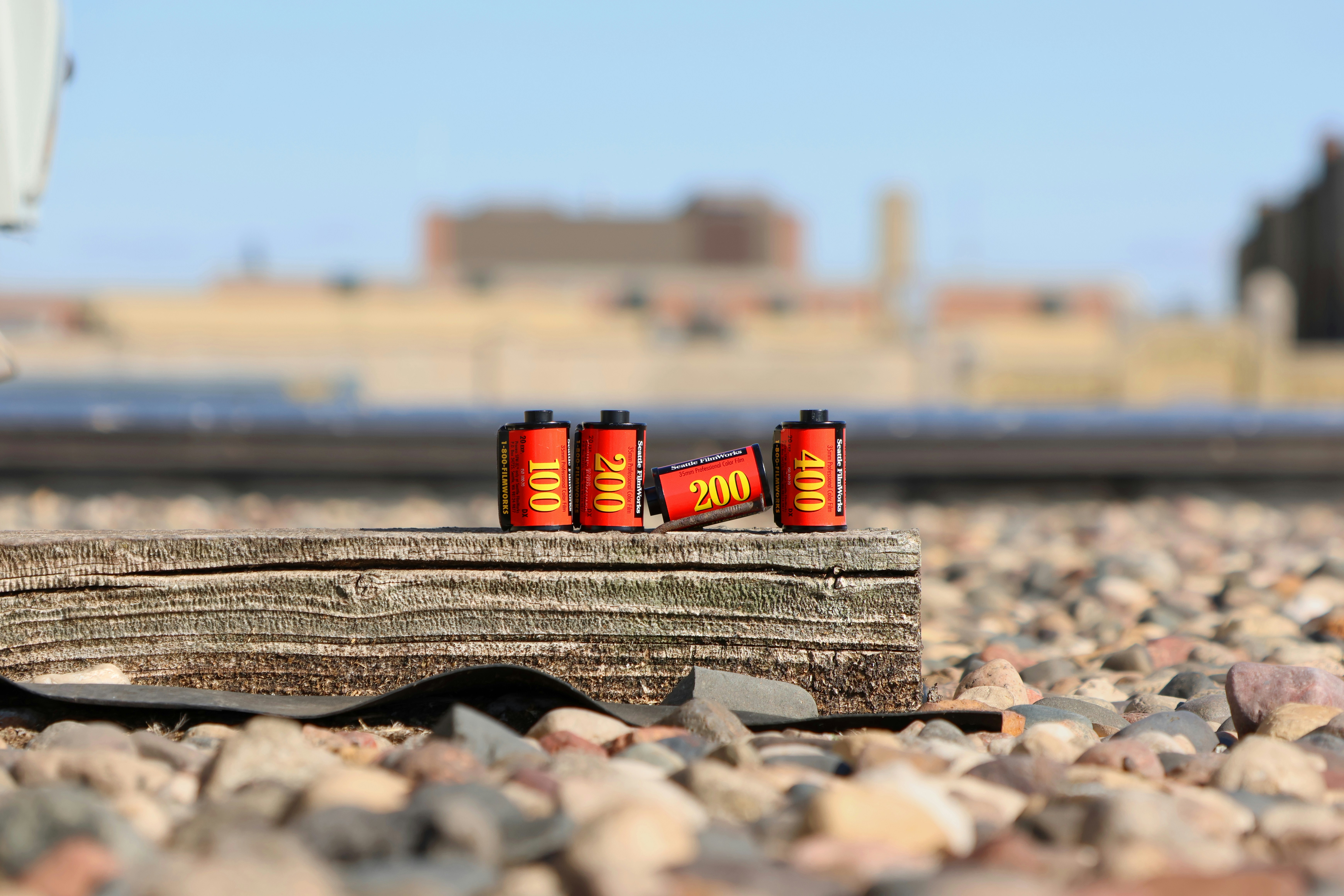 Miniature Countdown: A Row of Red-Label Batteries on a Weathered Plank