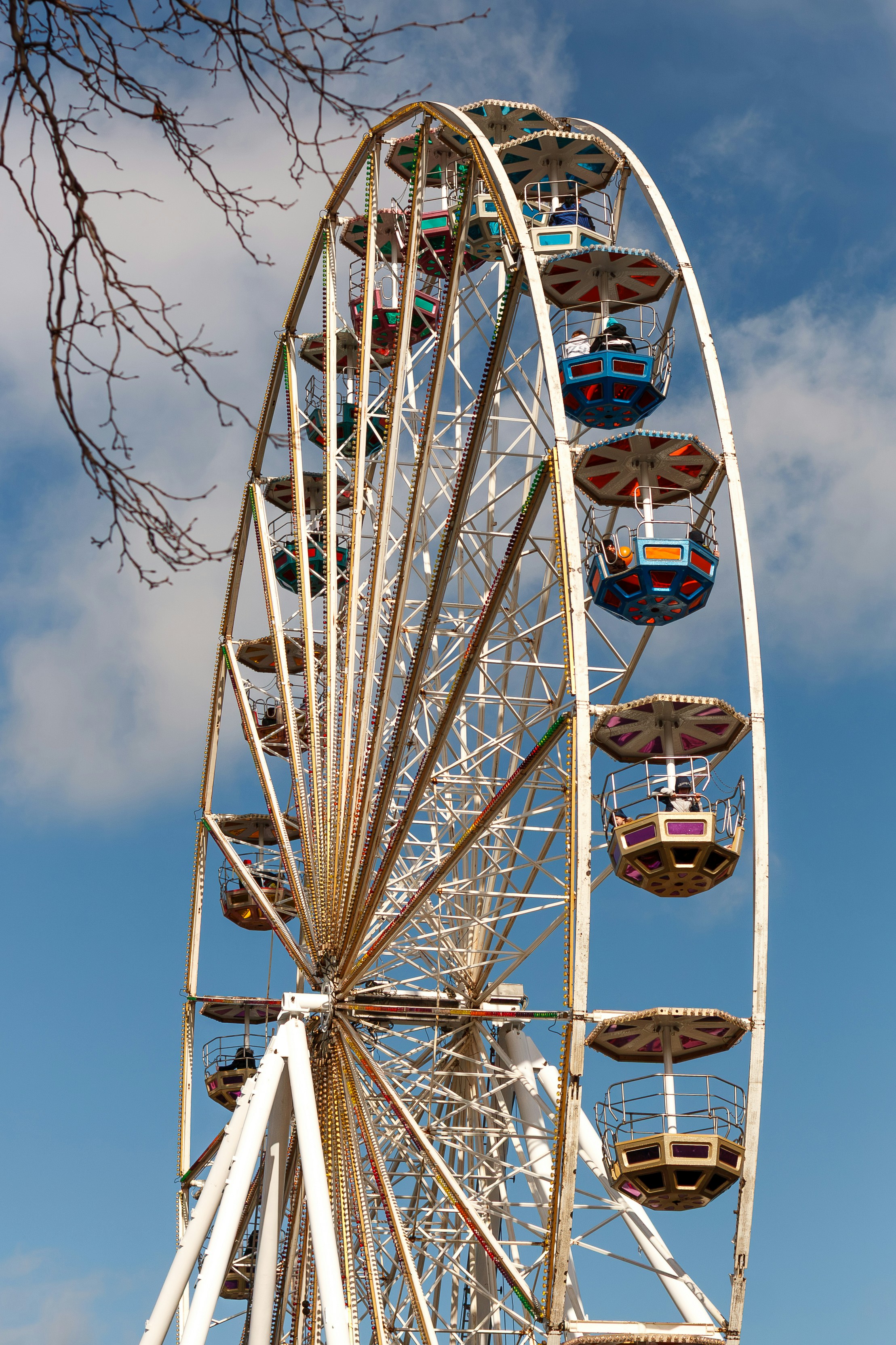 Circular Skyward: A Colorful Ferris Wheel Reaches into a Bright Blue Morning