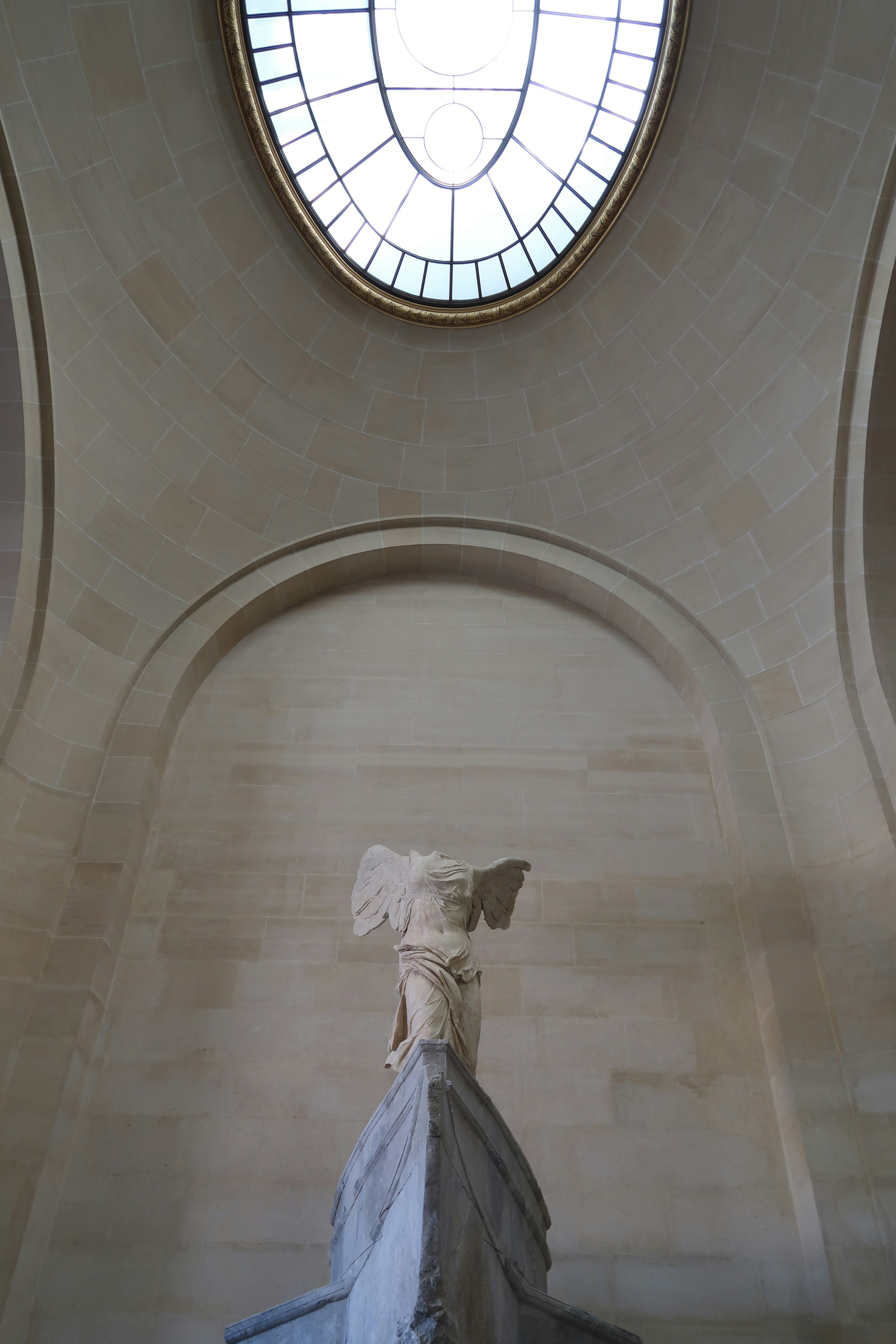Winged Statue at the Apex of Light: A Cathedral Oculus Scene