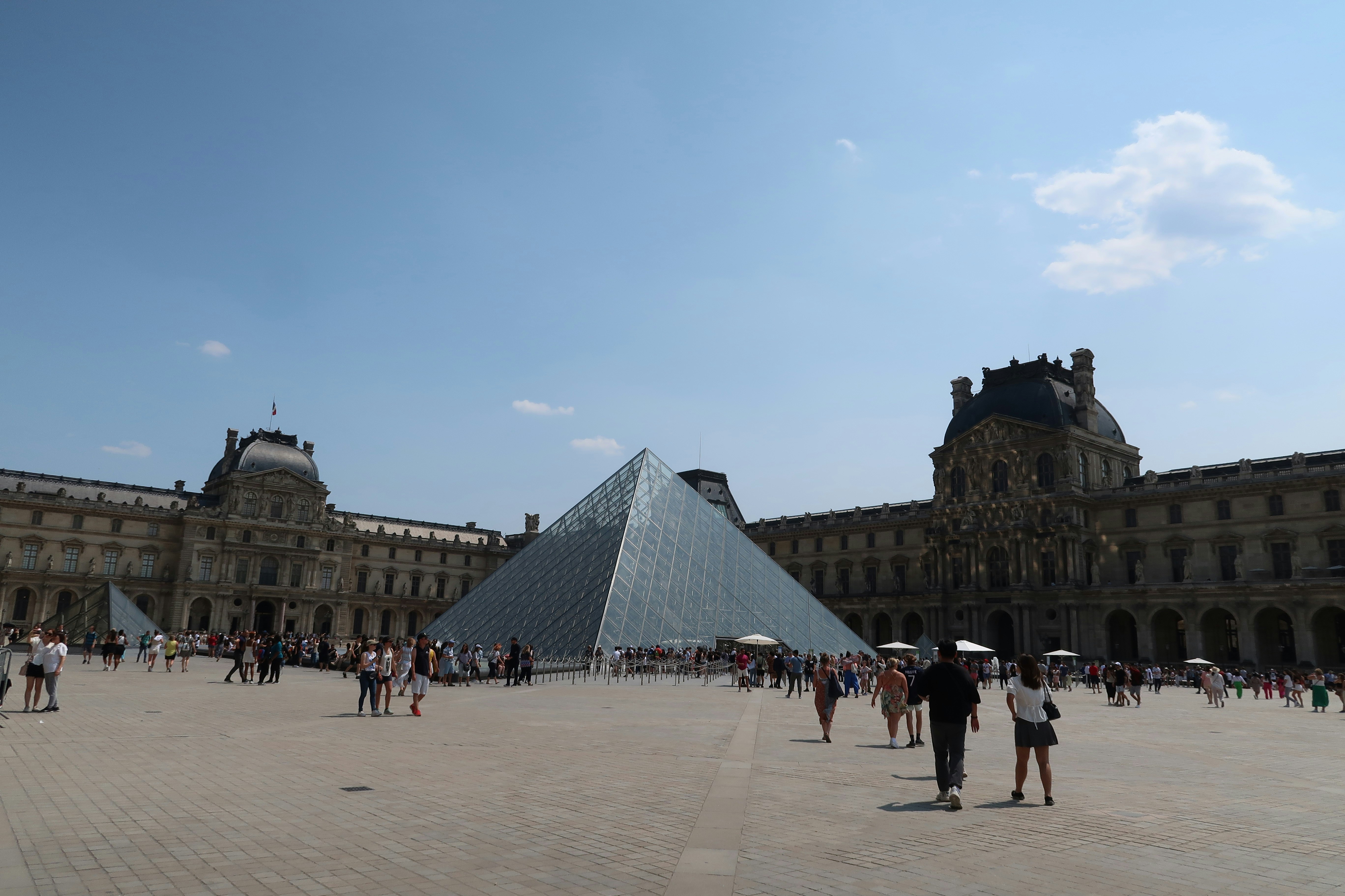 Glass Pyramid at Louvre: A Sunlit Courtyard Beneath Classic Architecture