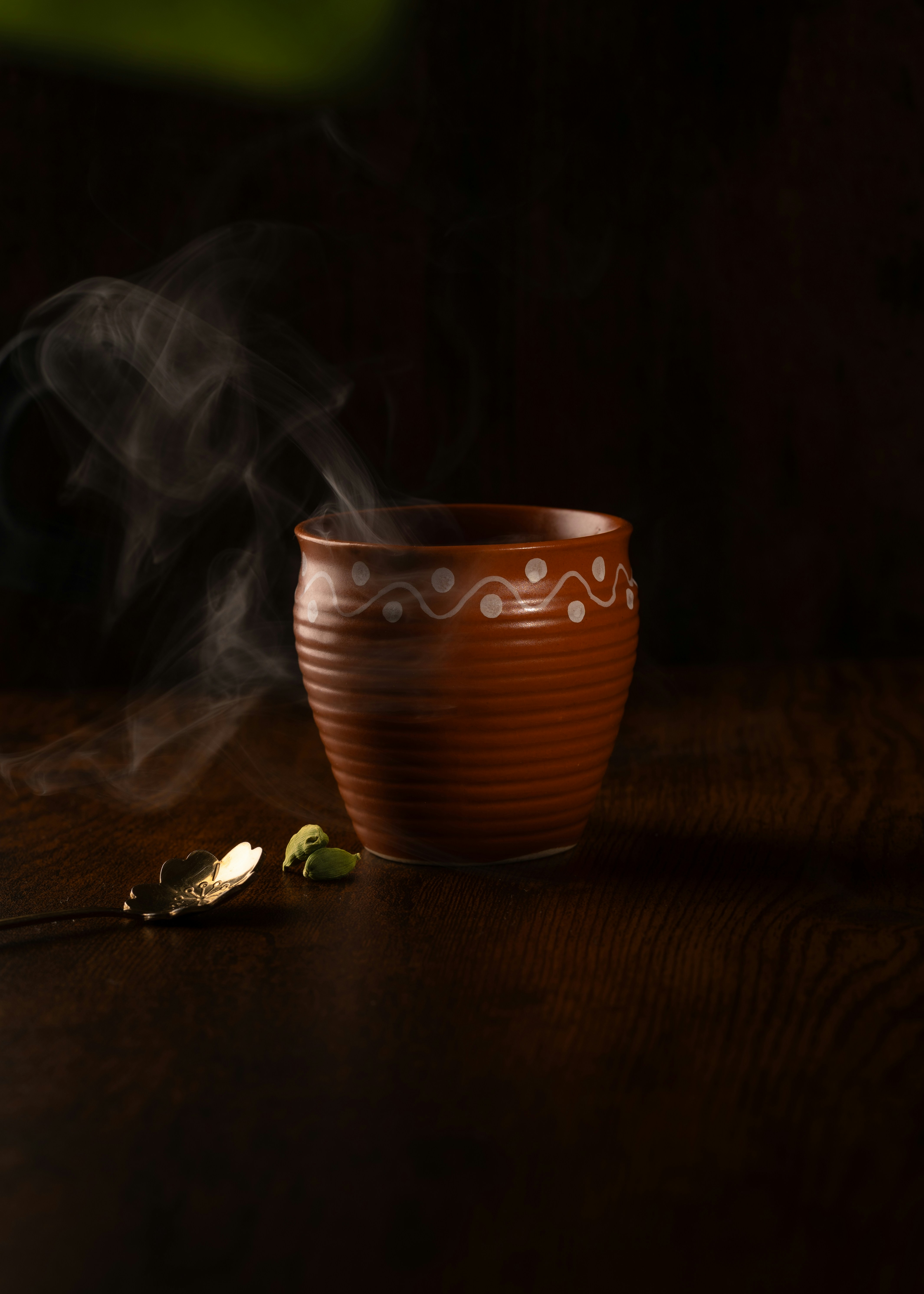 Steam-Wreathed Minimalism: A Terracotta Cup on a Midnight Table