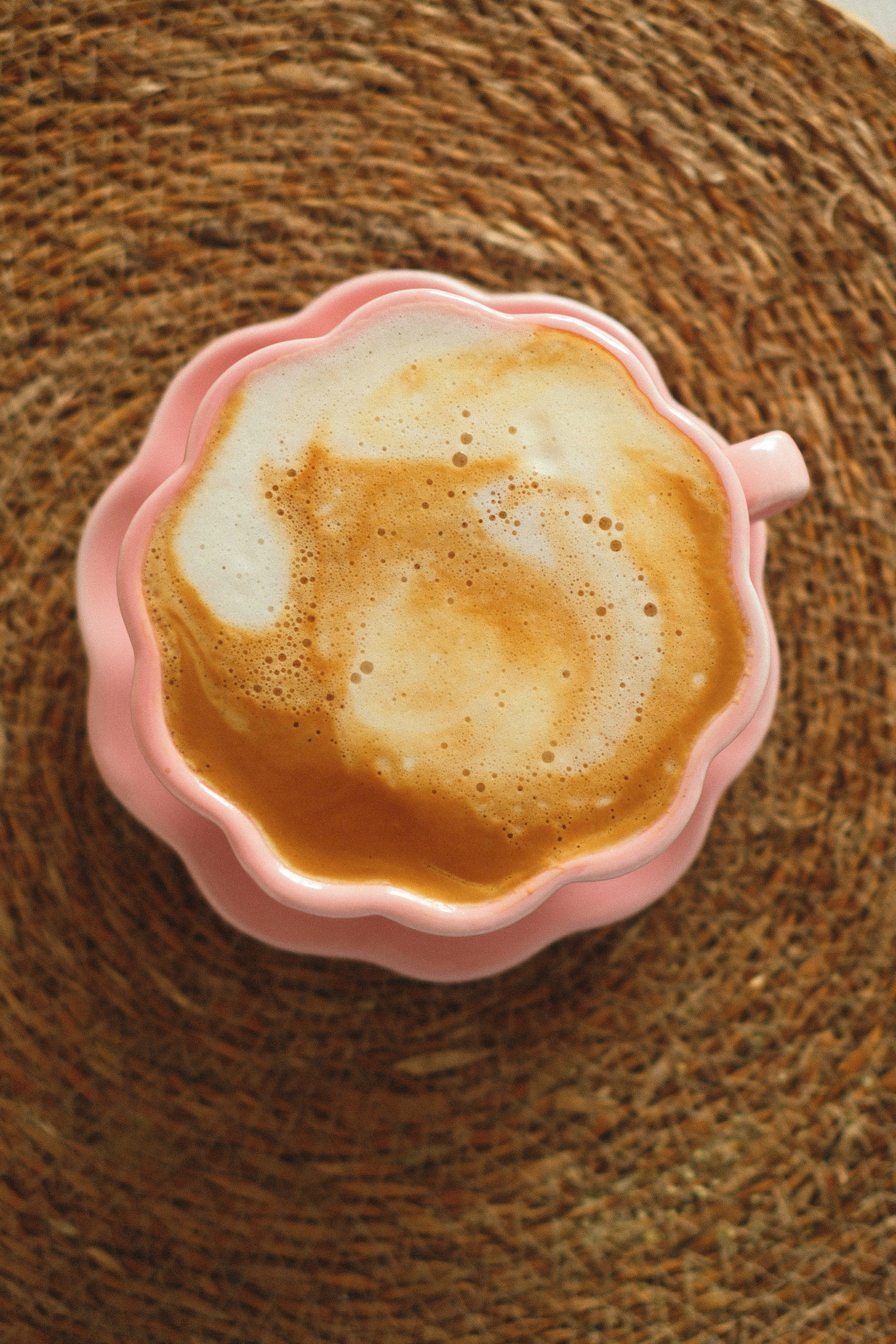 Rosy Cup of Foam: Aerial Latte Portrait on a Woven Table