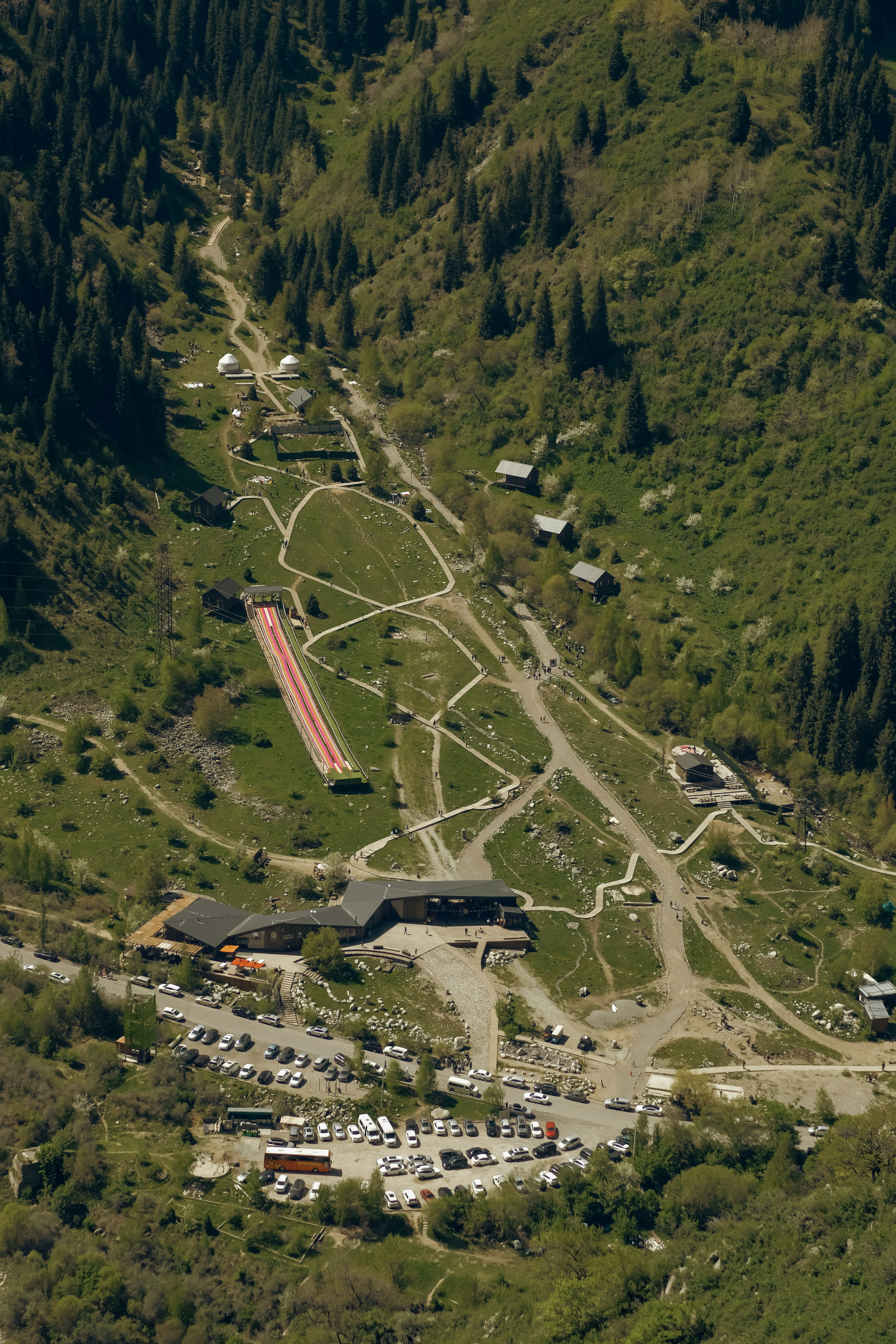 A mountain hillside village streaked with a bright ski ramp