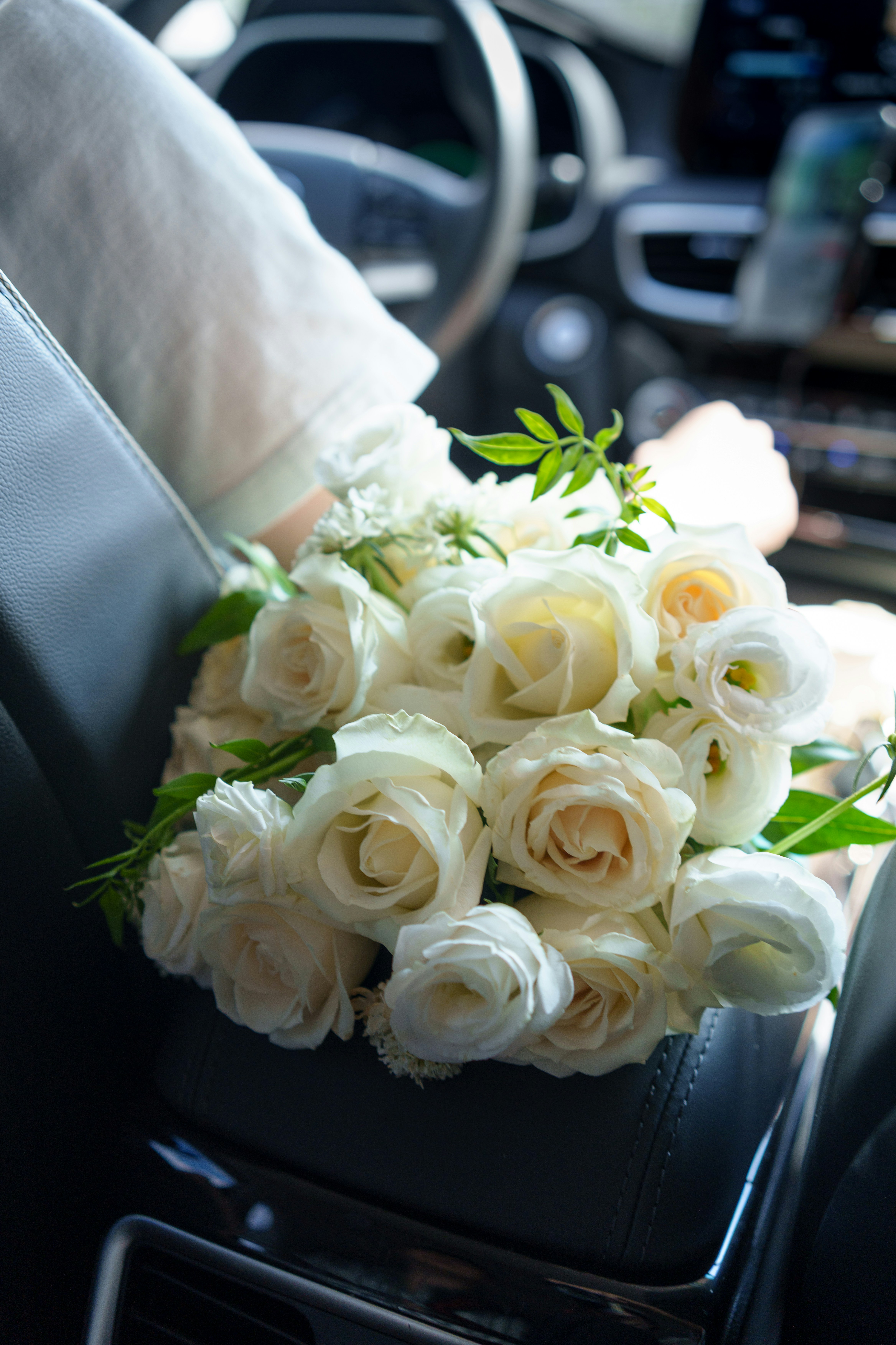 White Rose Bouquet resting in a car's center console