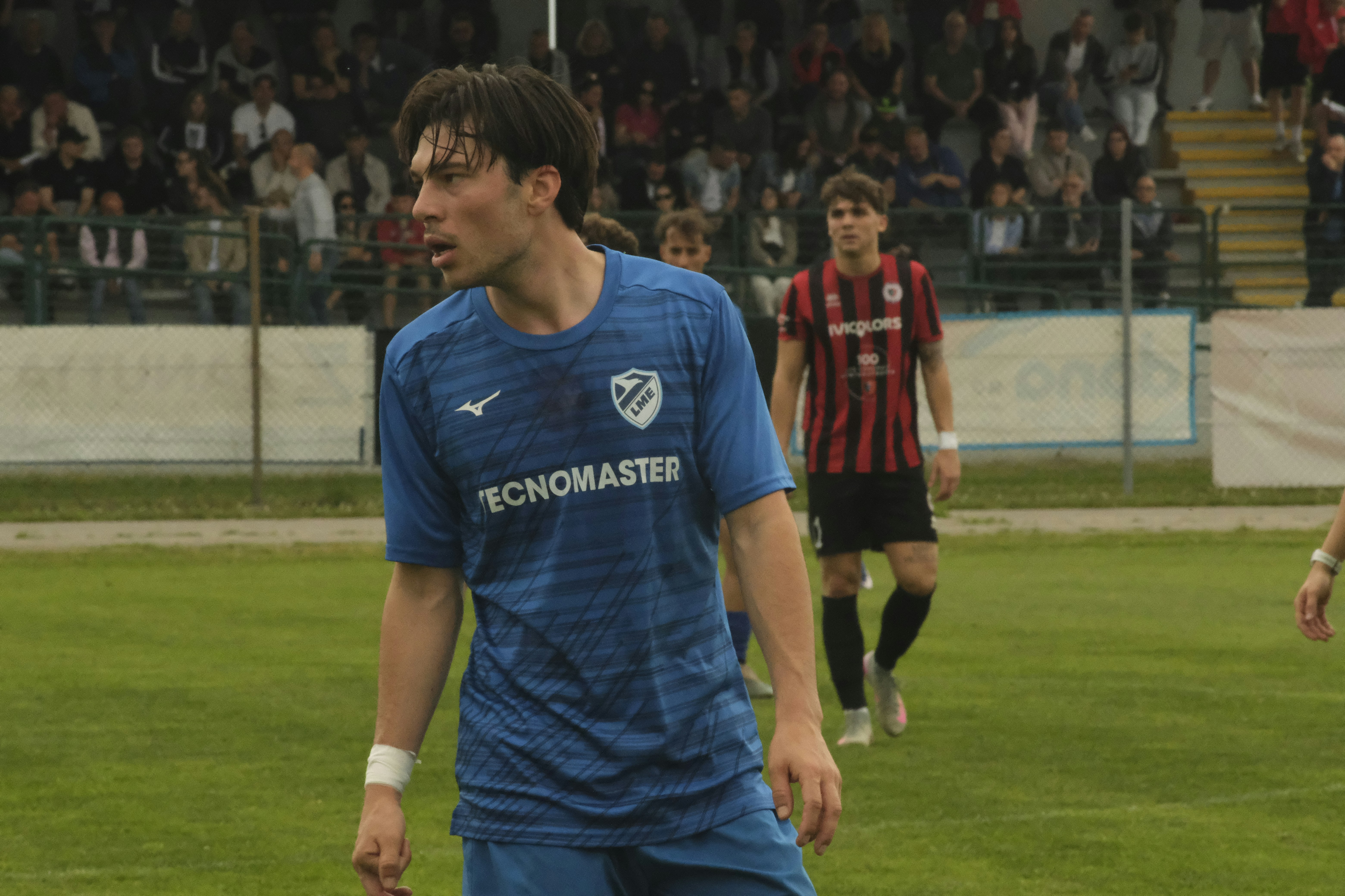 Blue-dressed winger charges forward under stadium lights