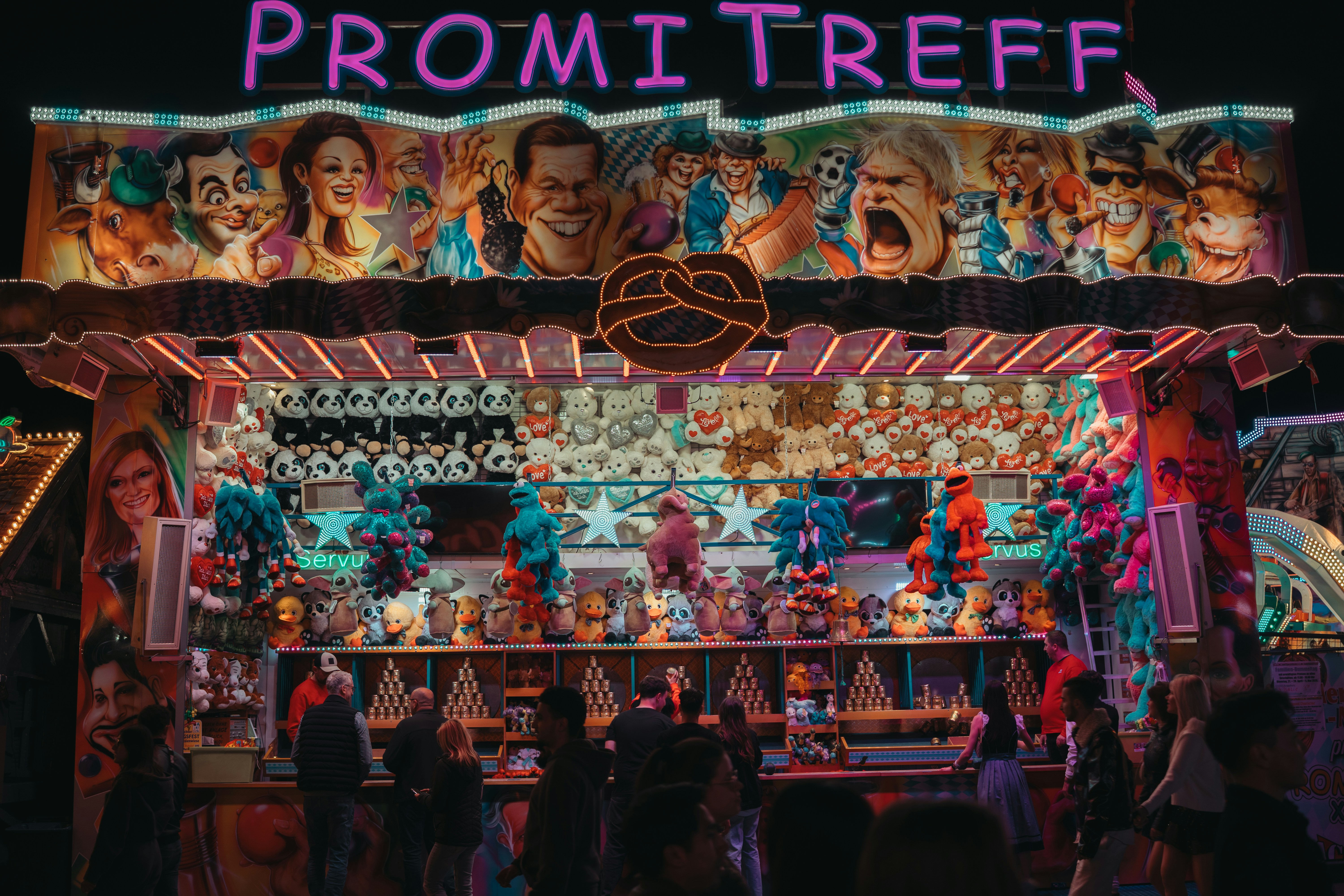 Prominent Fairground Facade: Neon Sign Lighting Up a Bustling Stall