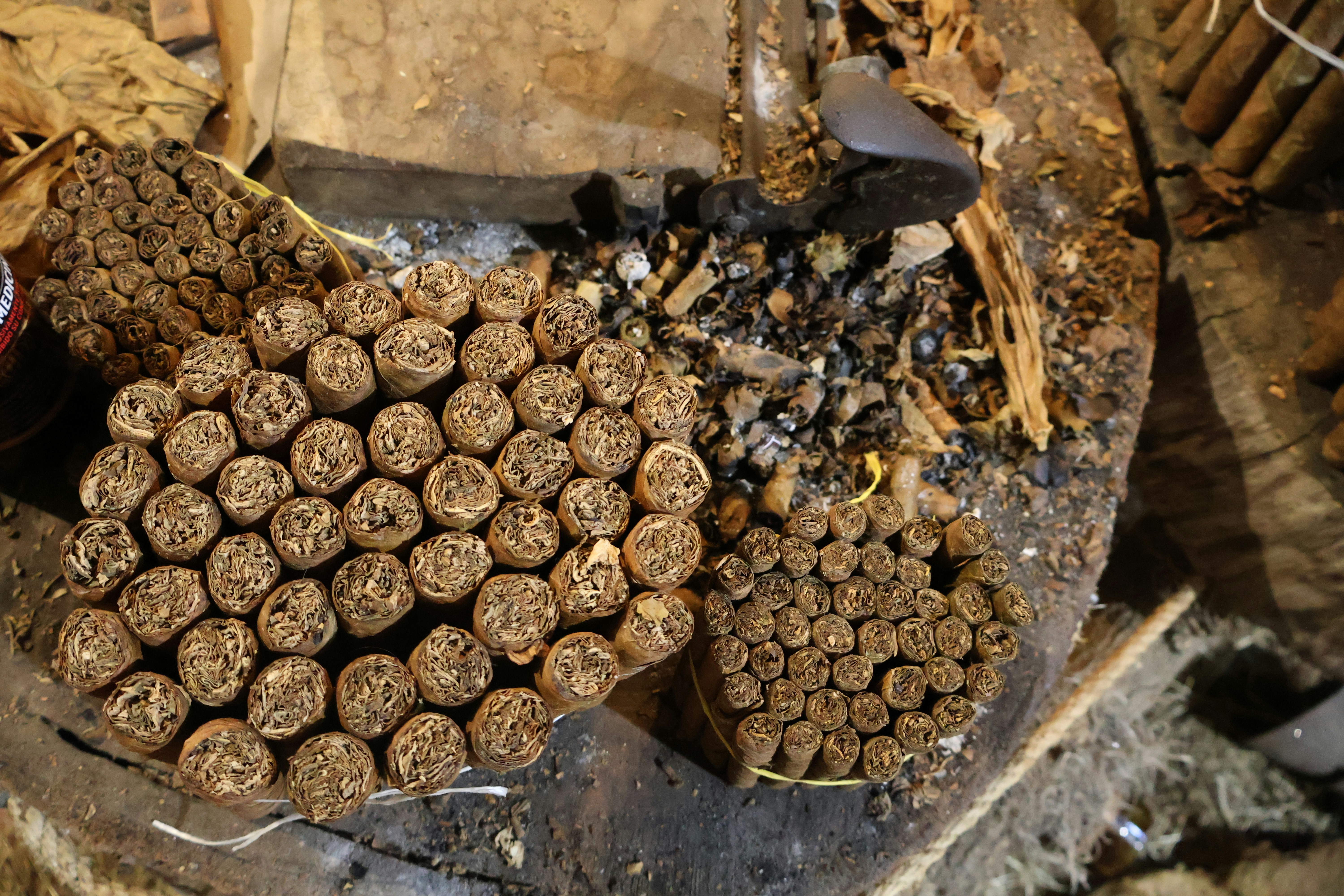 Bundles of charcoal stubs stacked in a rustic workshop