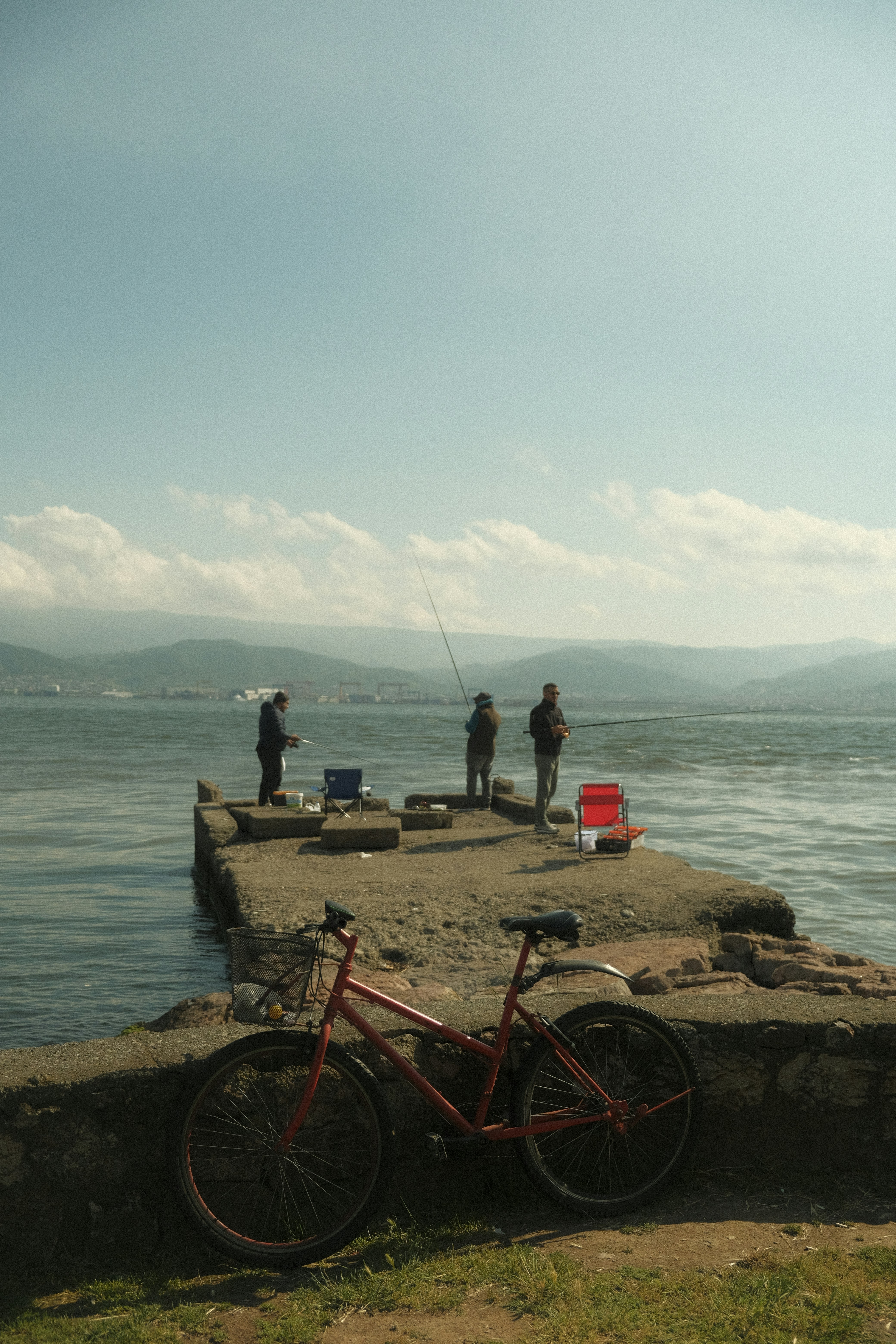 Red Bicycle at the End of the Pier under a Calm Coastal Sky