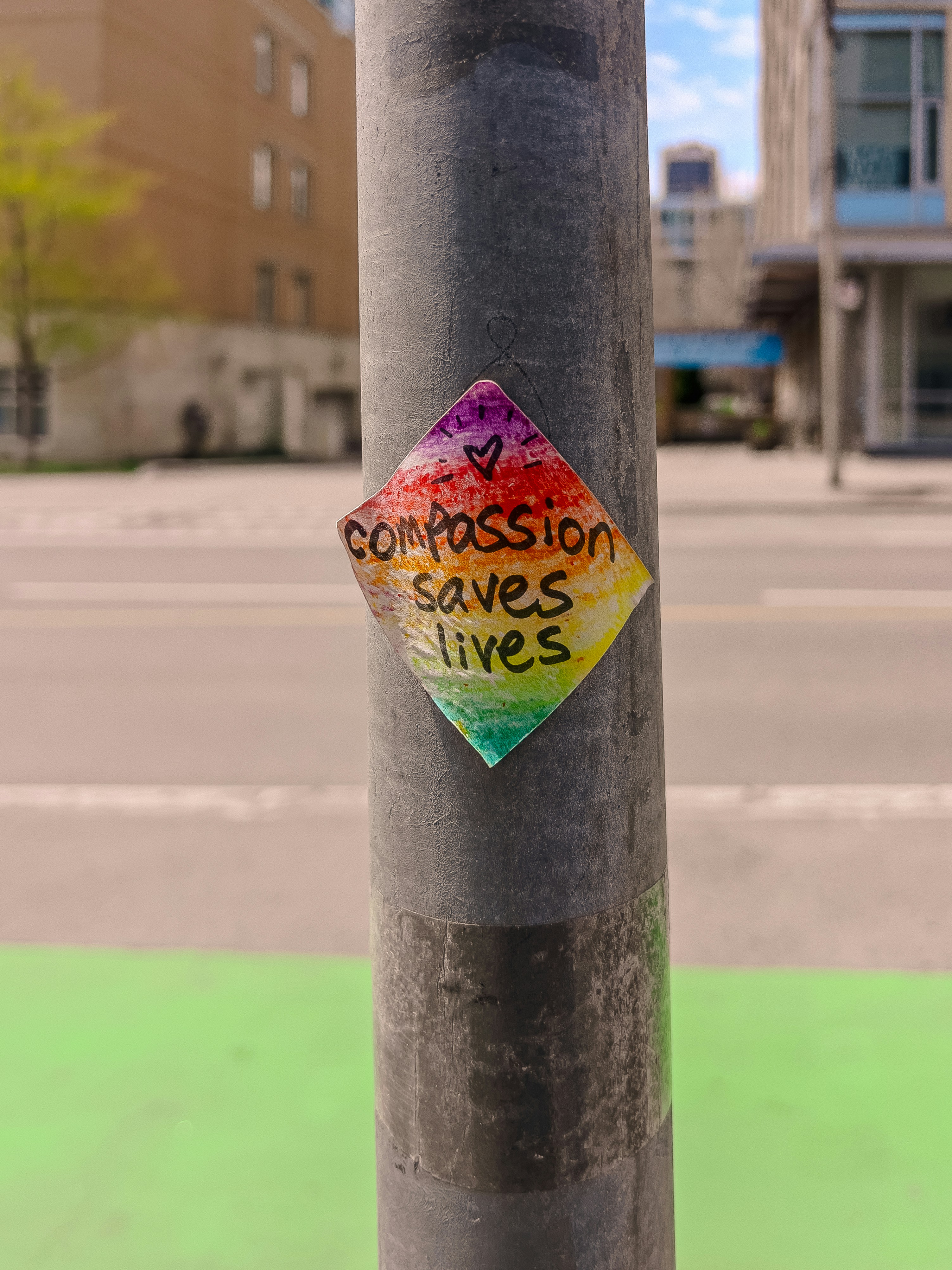 Rainbow Sticker on a Street Pole: Compassion in the City