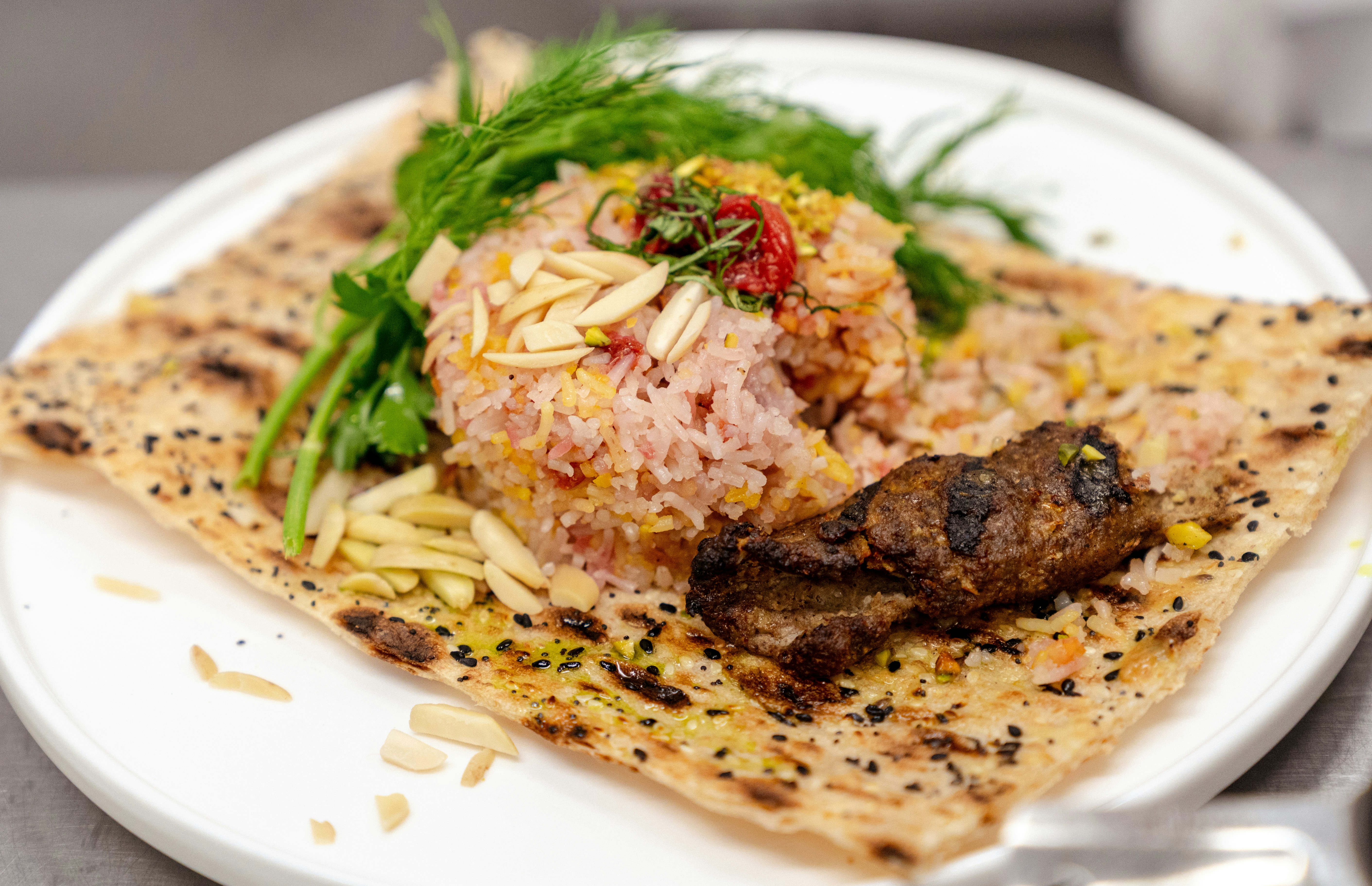 Rice on Flatbread: A Rustic Plate of Herb-Studded Mutton and Toasted Almonds