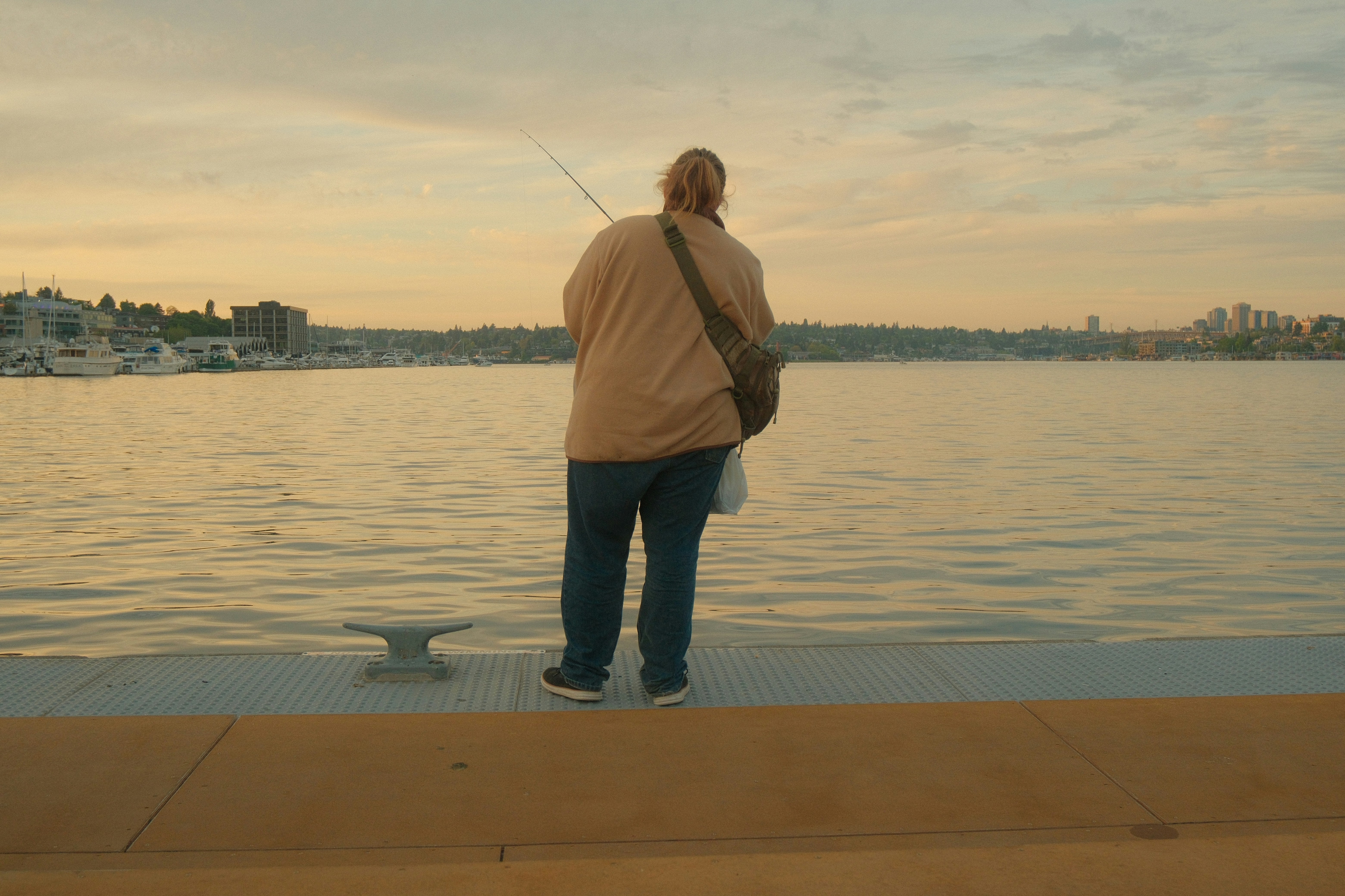 Person fishing from a dock at sunset