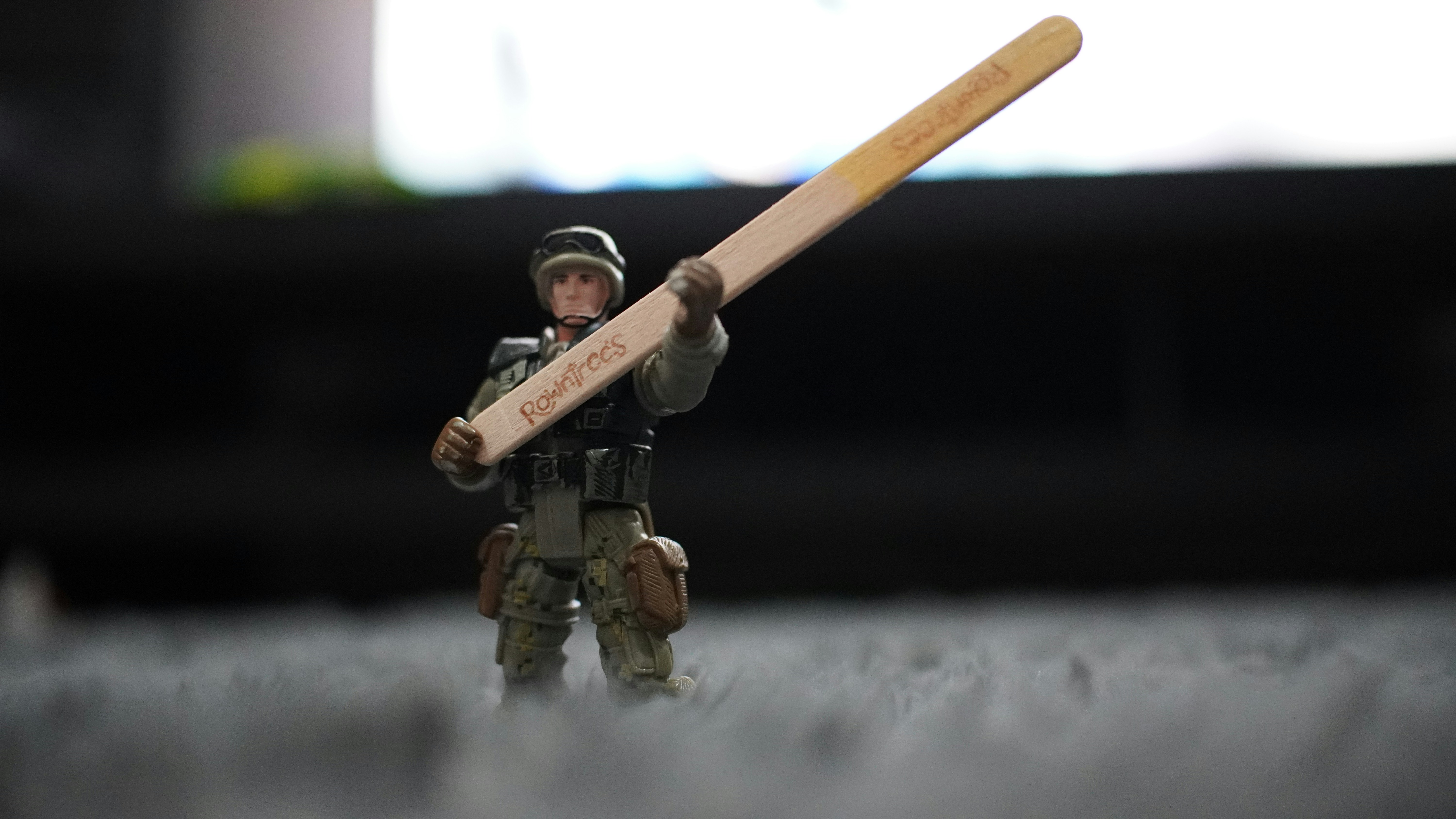 Tiny Ranger Advances with a Wooden Blade Across a Carpet Battlefield