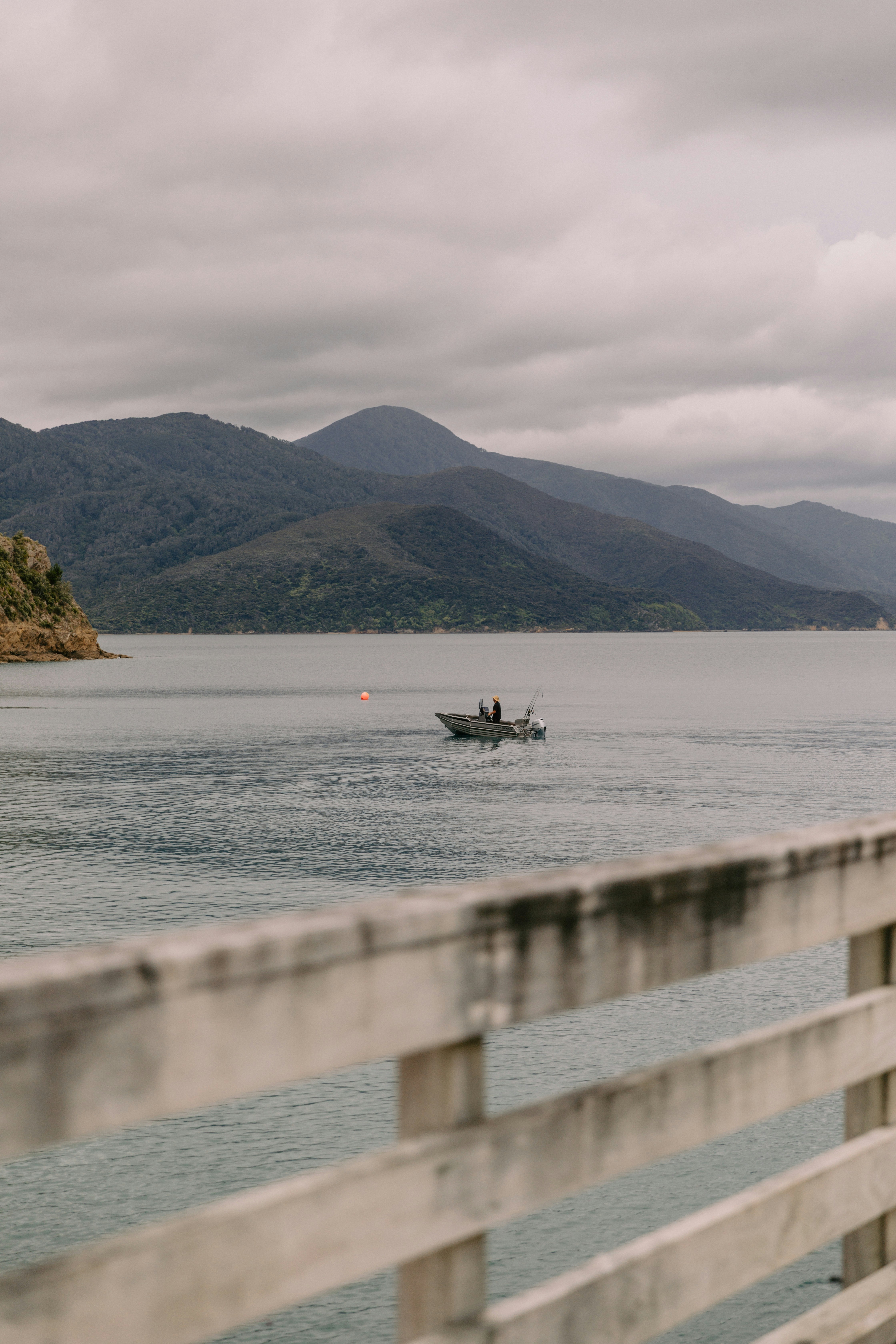 Boat on tranquil bay framed by distant mountains