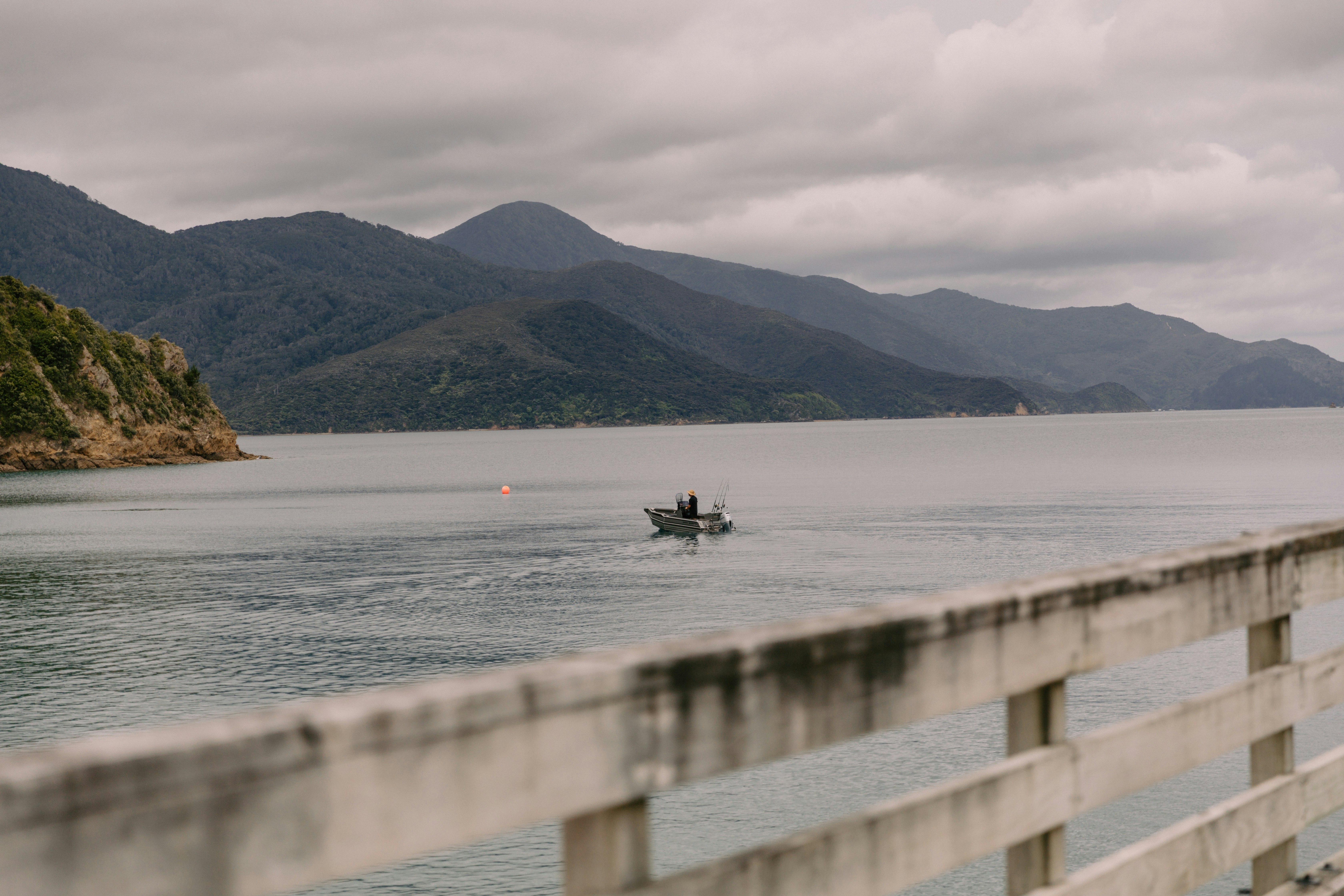 A Quiet Harbor: Boat in a Misty Bay Framed by a Weathered Pier