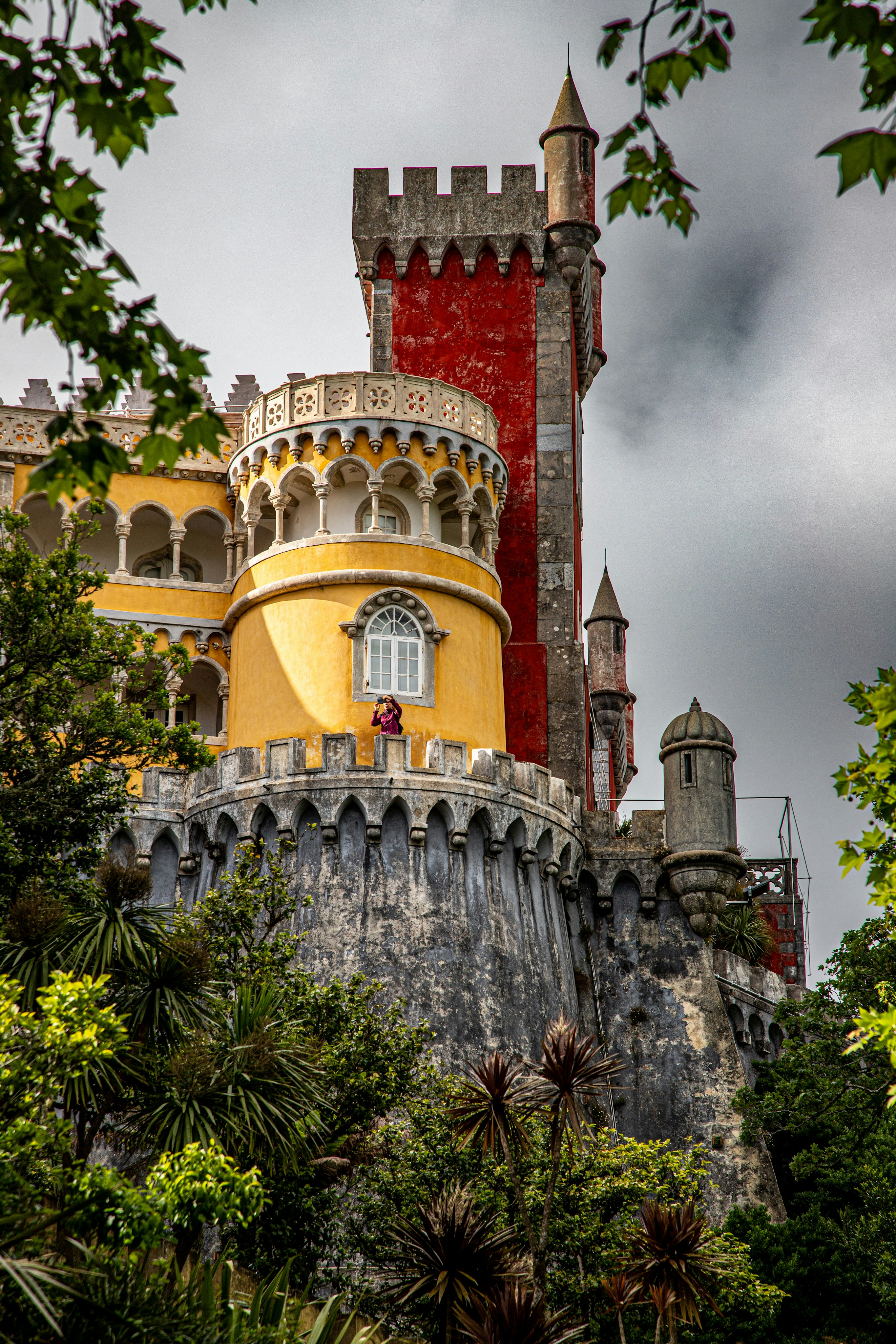 Castle in Color: The Yellow Turret Overlooking a Lush Rock Terrace