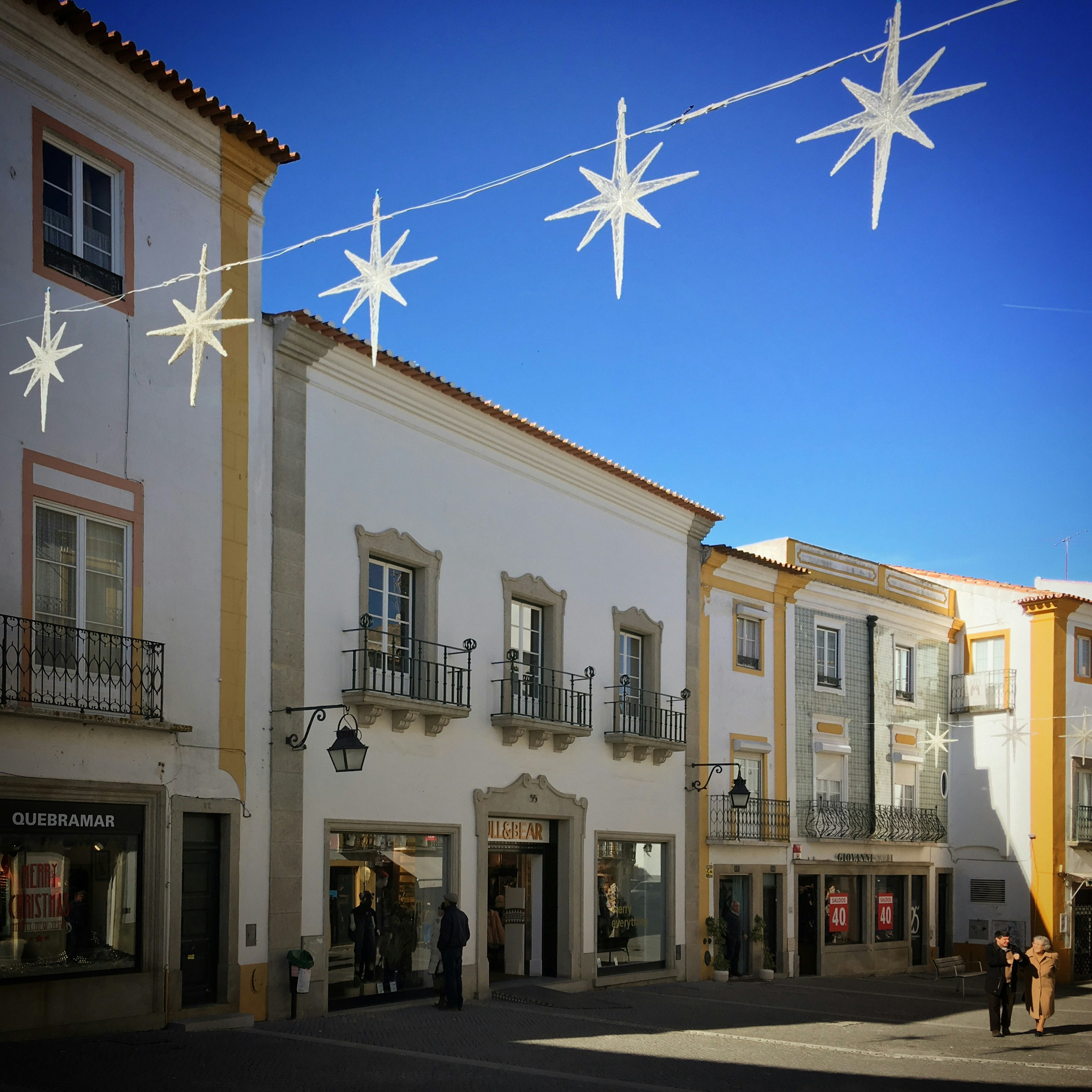 Starry Streetlights Over a Sunlit Catalan Facade