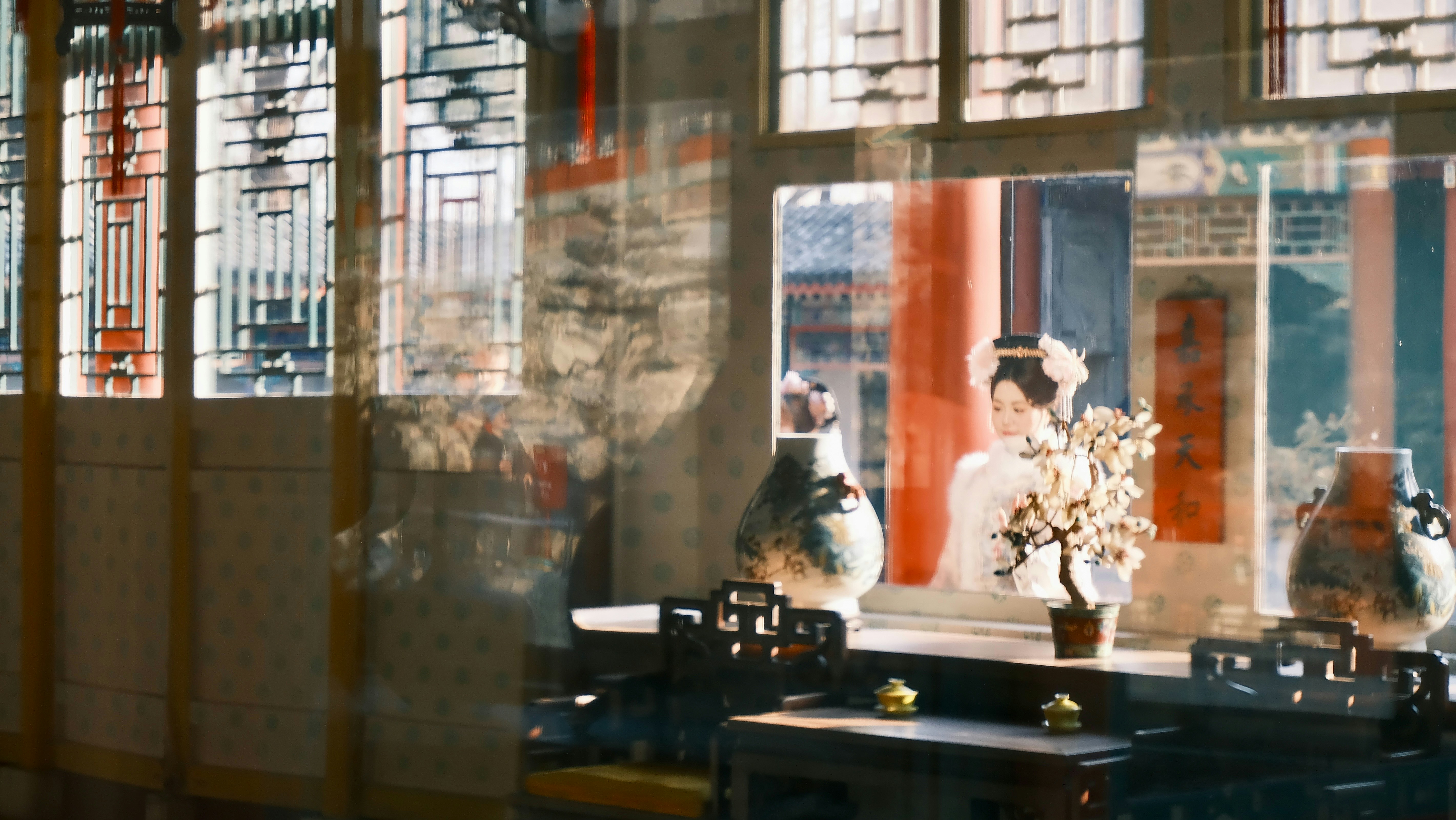 Subtle interior scene revealing a traditional teahouse with a softly dressed performer visible through a window; a warm, contemplative still-life setting with low light and vintage décor.