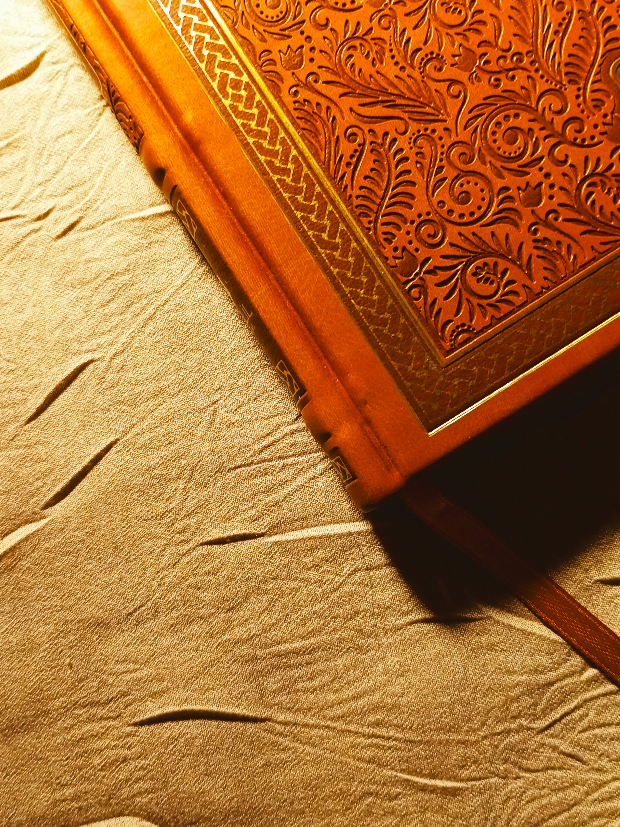Ornate Leather-Bound Corner Resting on Textured Fabric
