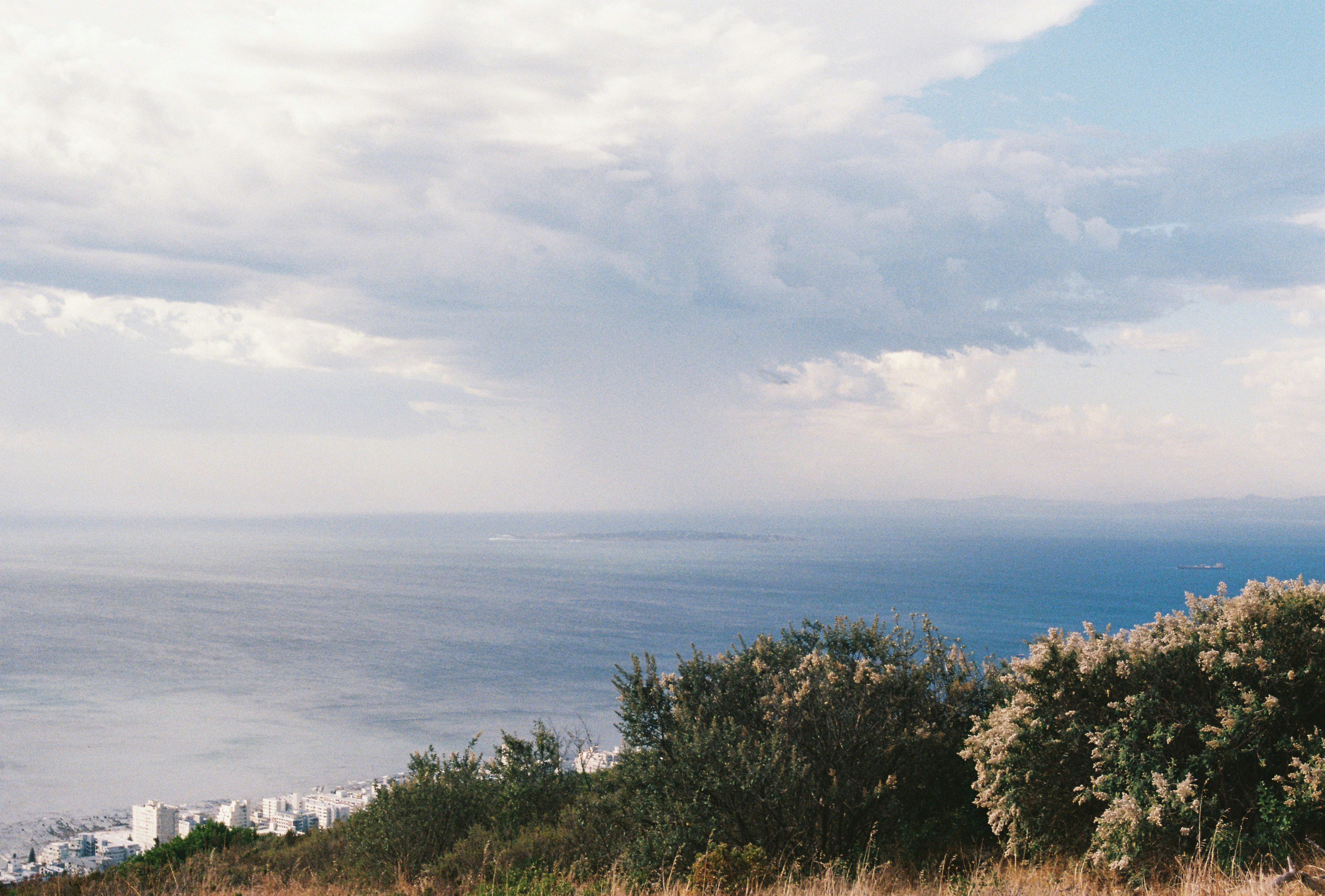 Coastal Awe: cliffside overlook toward a distant sea horizon