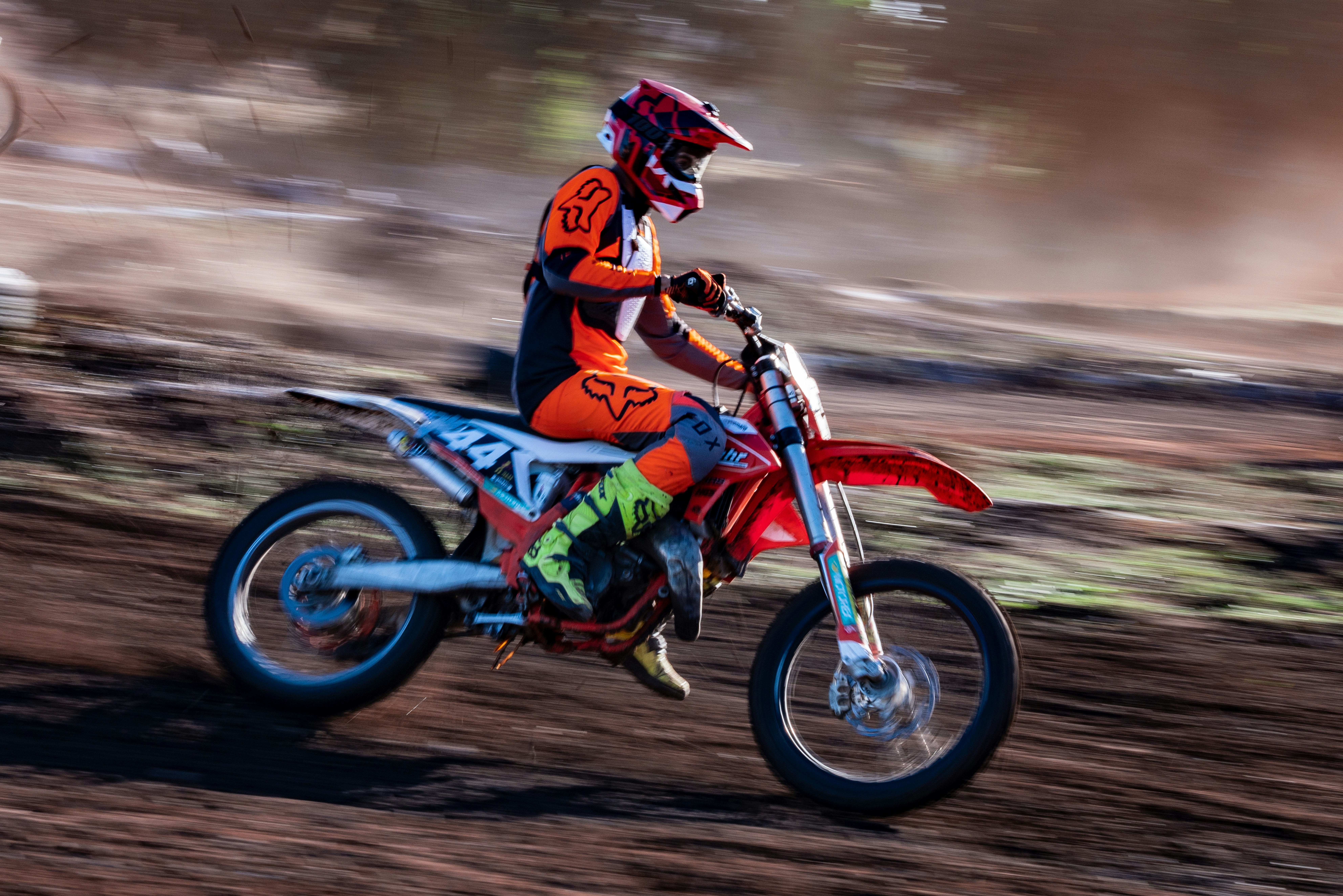 Rapid Ascent: A Moto rider clawing through a dusty off-road sprint