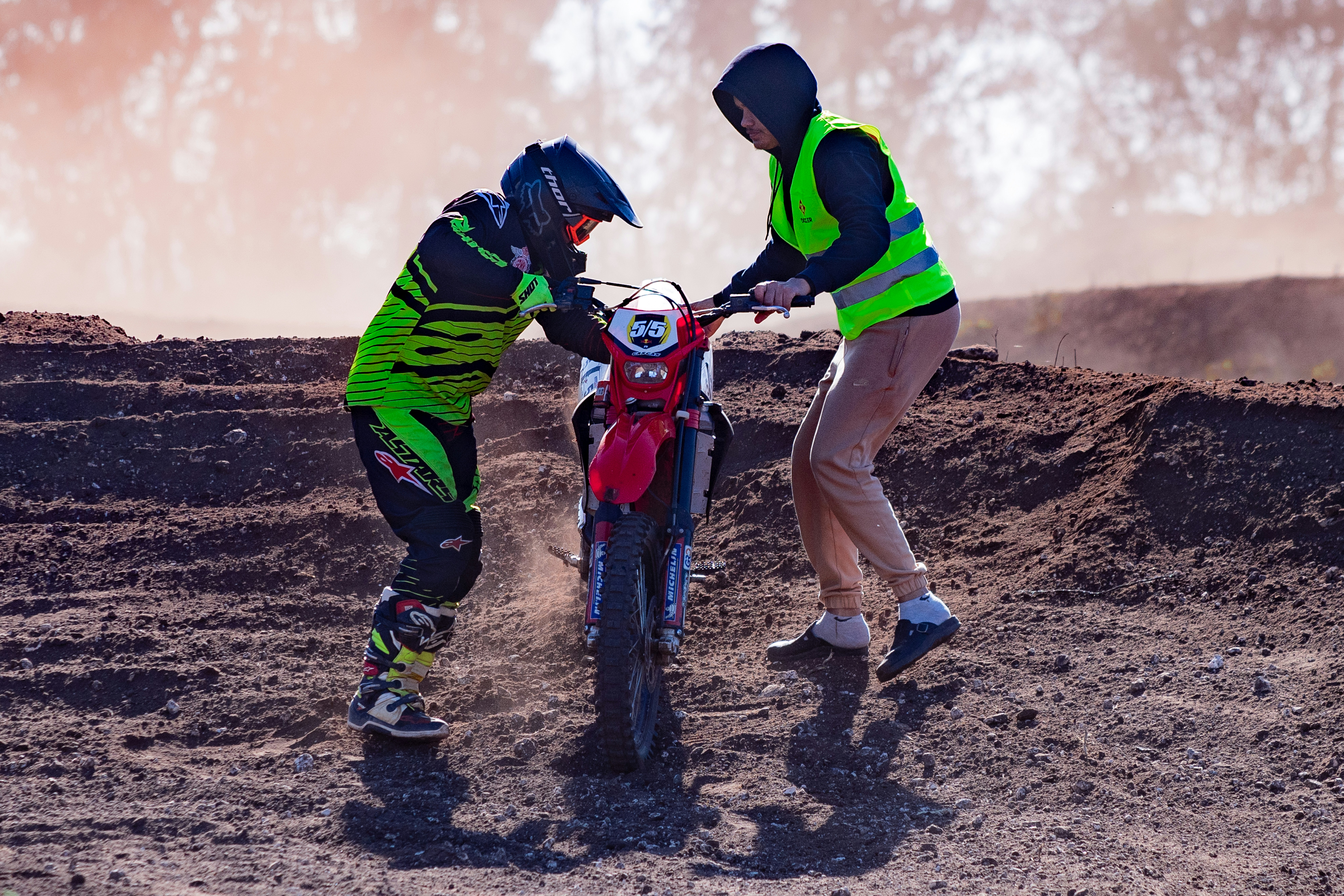 Two Helpers and a Dirt-Born Bike: Team Effort at the Motocross Stall