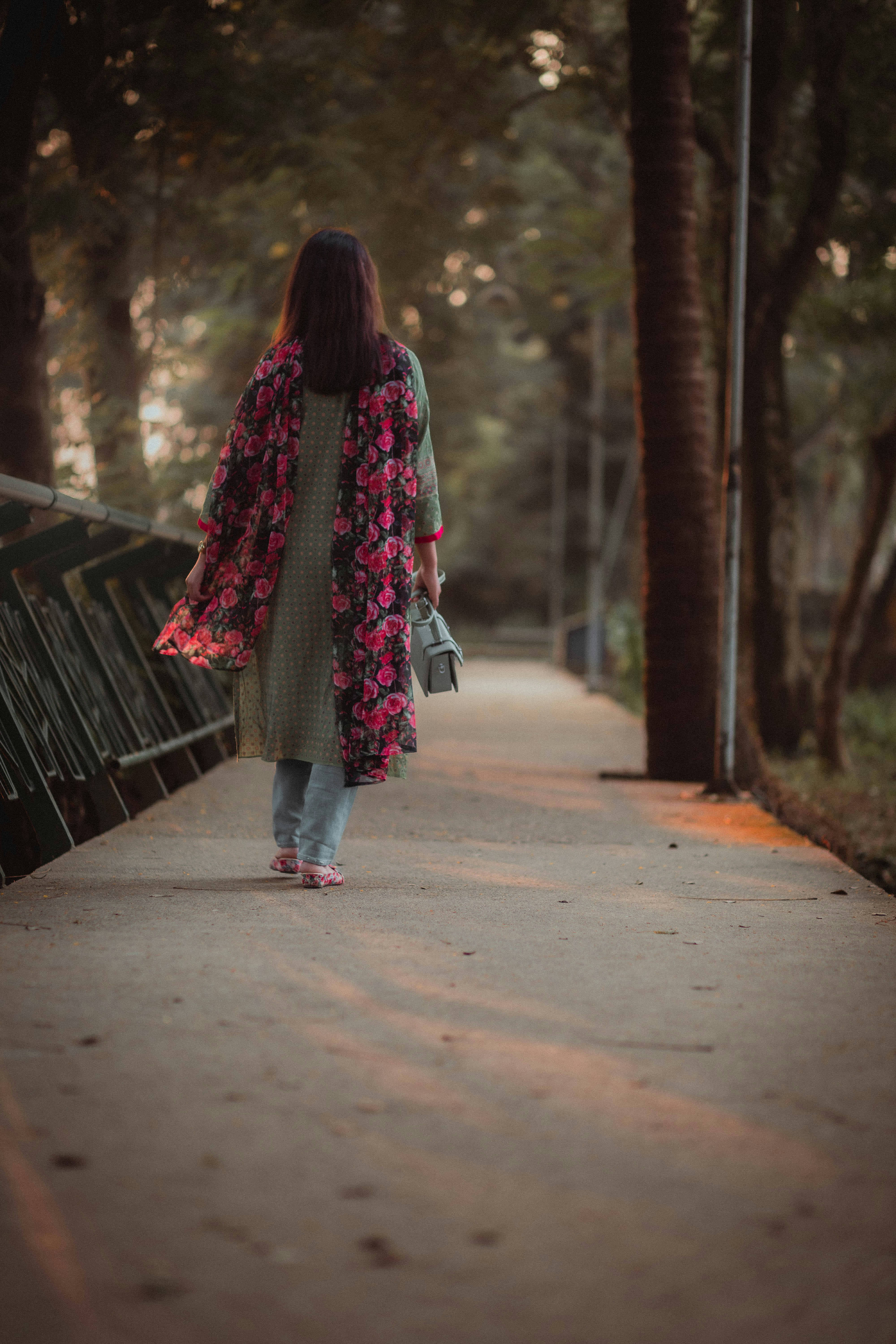 A Quiet Walk Under Autumn Light: Woman in Floral Shawl Pausing on a Tree-Lined Path