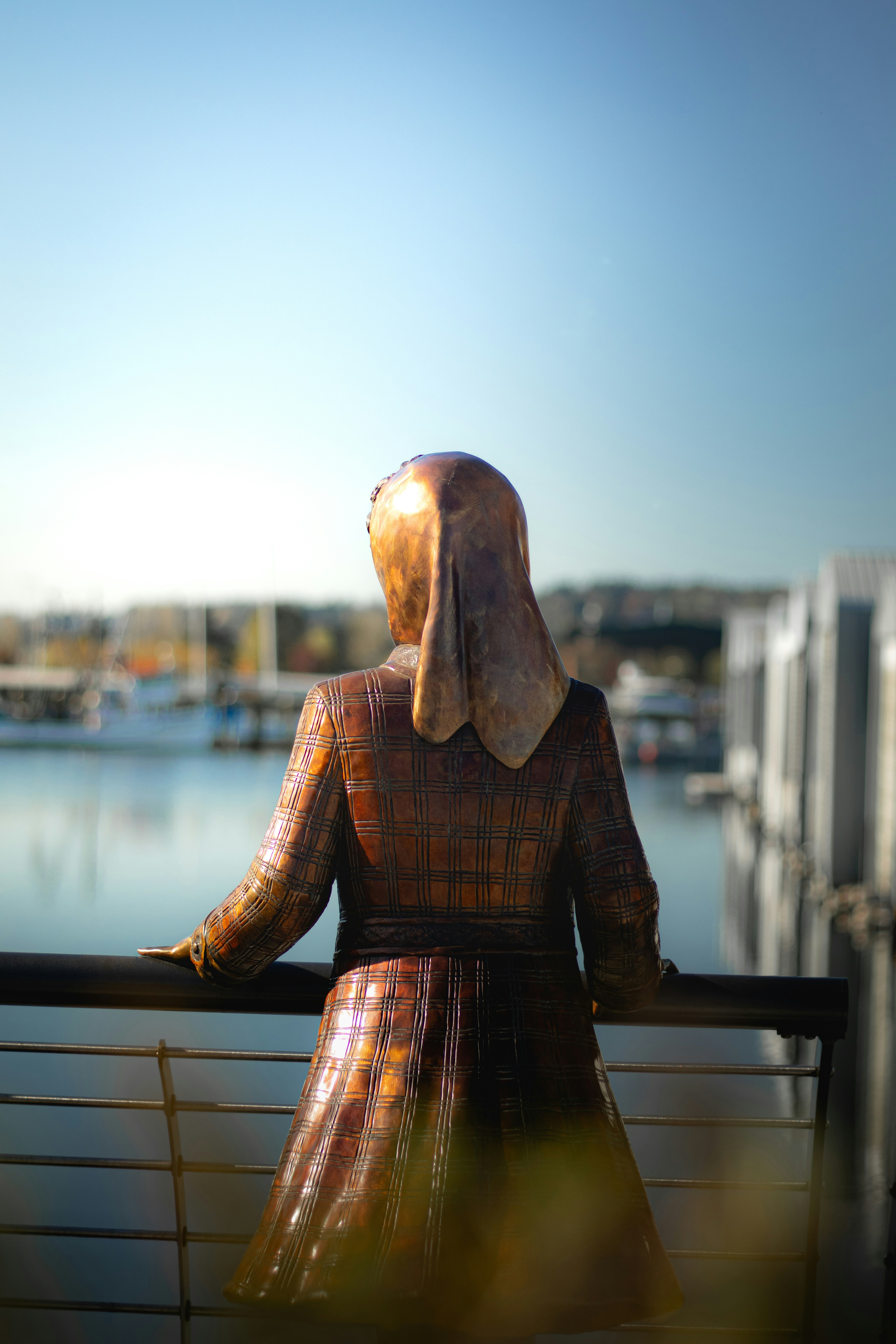 Backlit Silhouette: A Dressed Figure Overlooking the Harbor