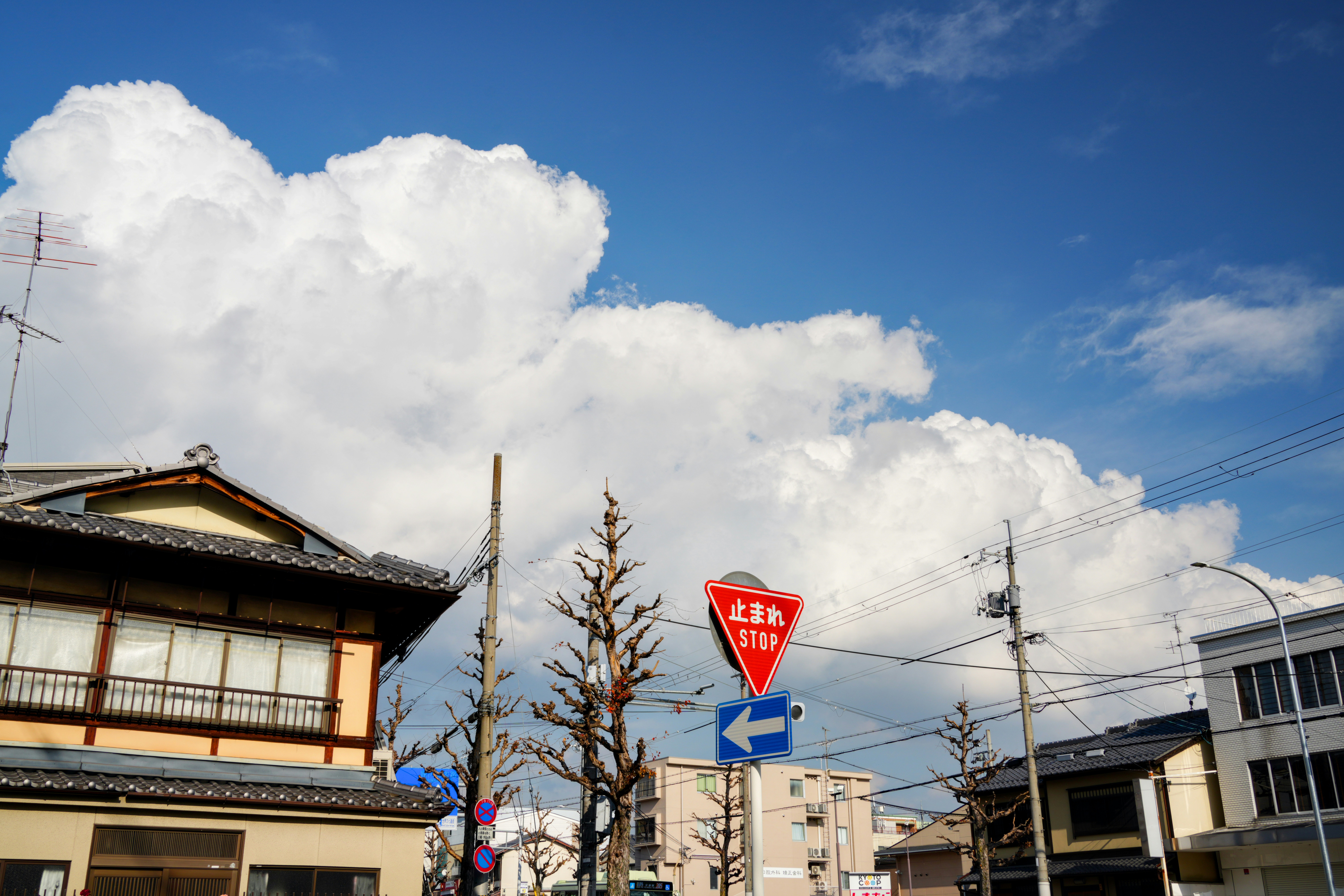 Urban Stop Sign: Quiet Street Under Billowy Clouds