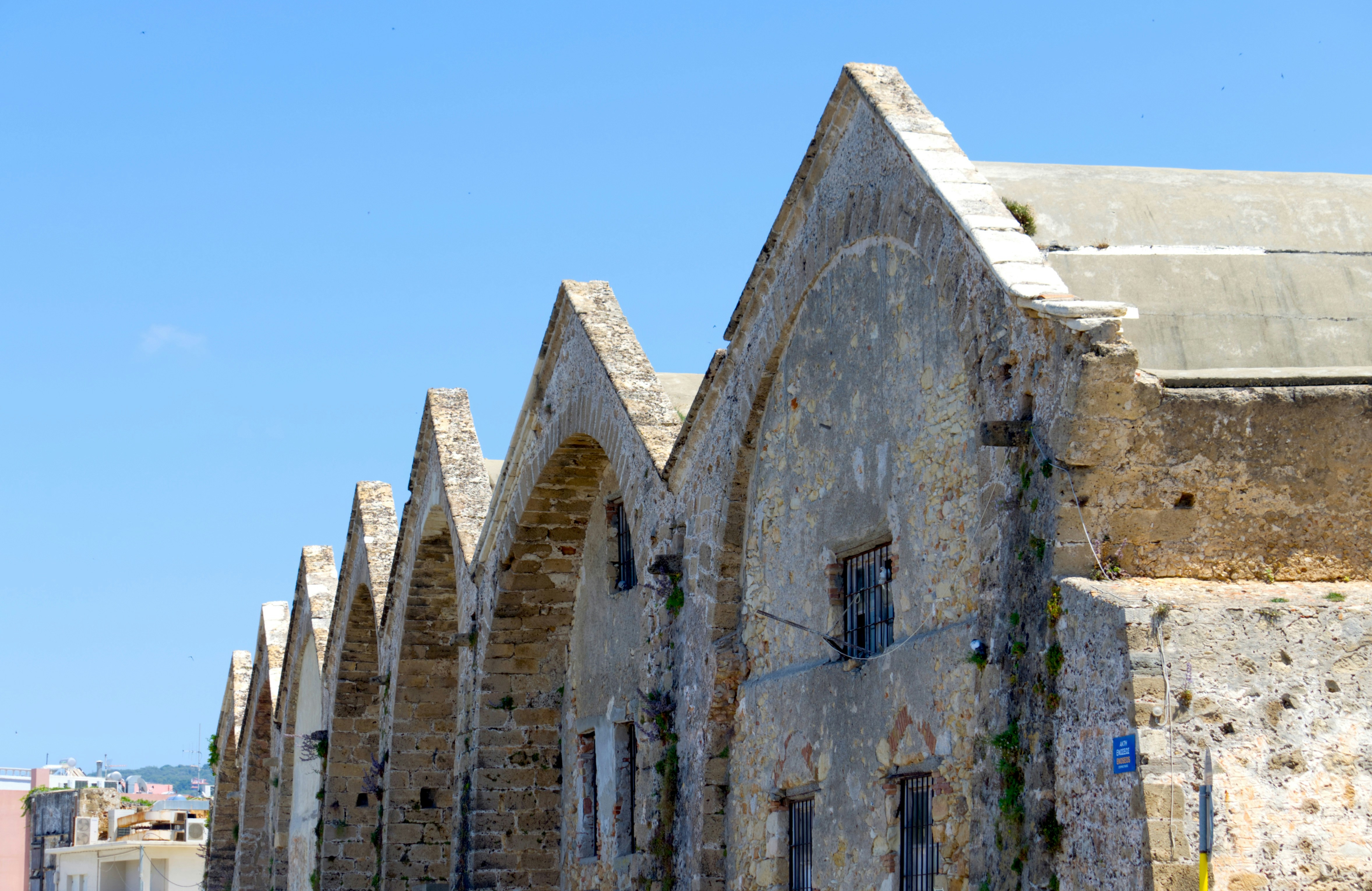 A row of limestone arches against a bright coastal sky