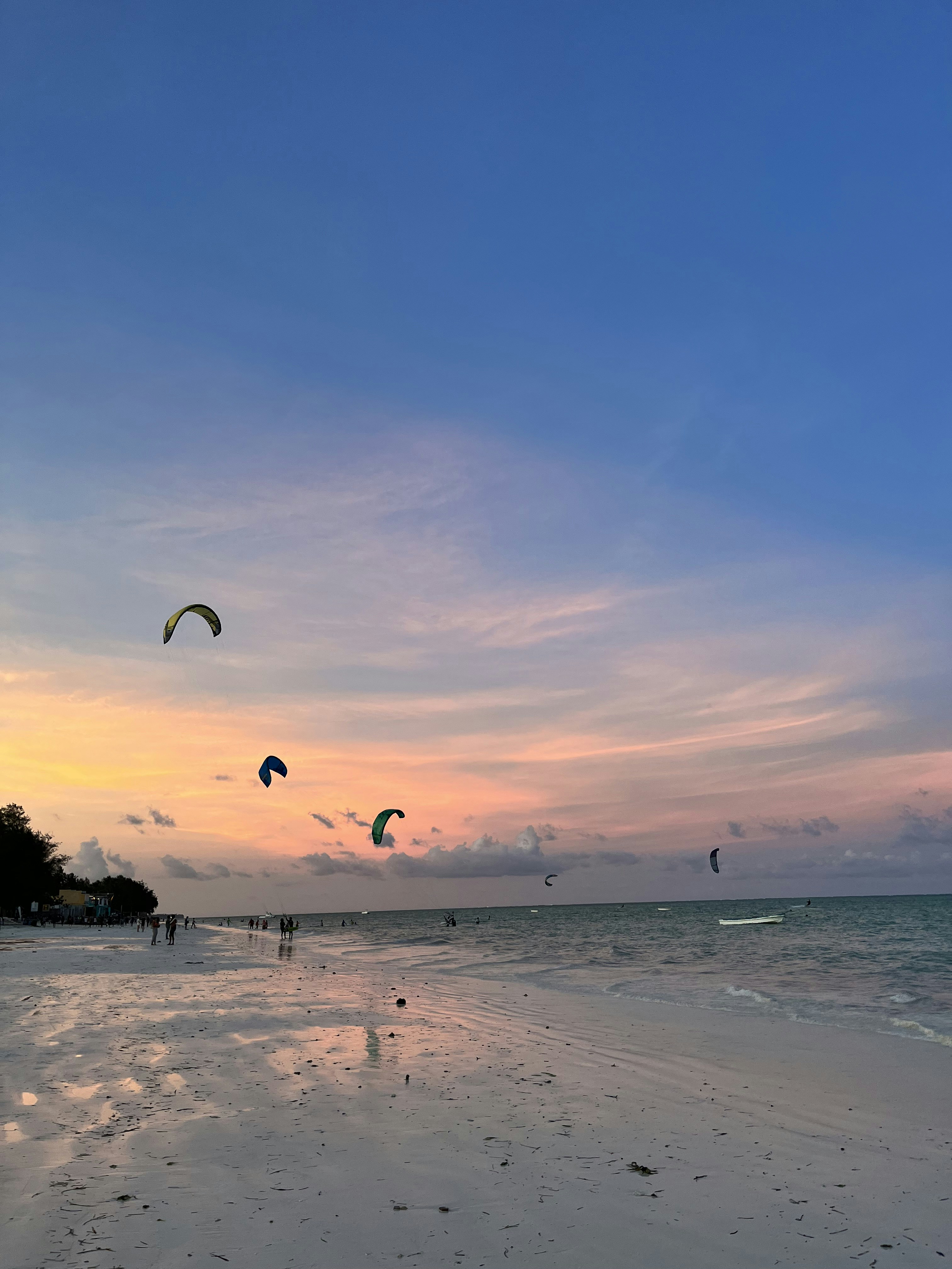 Sunset on the Seafront: Kite Surfers dance along a pastel horizon