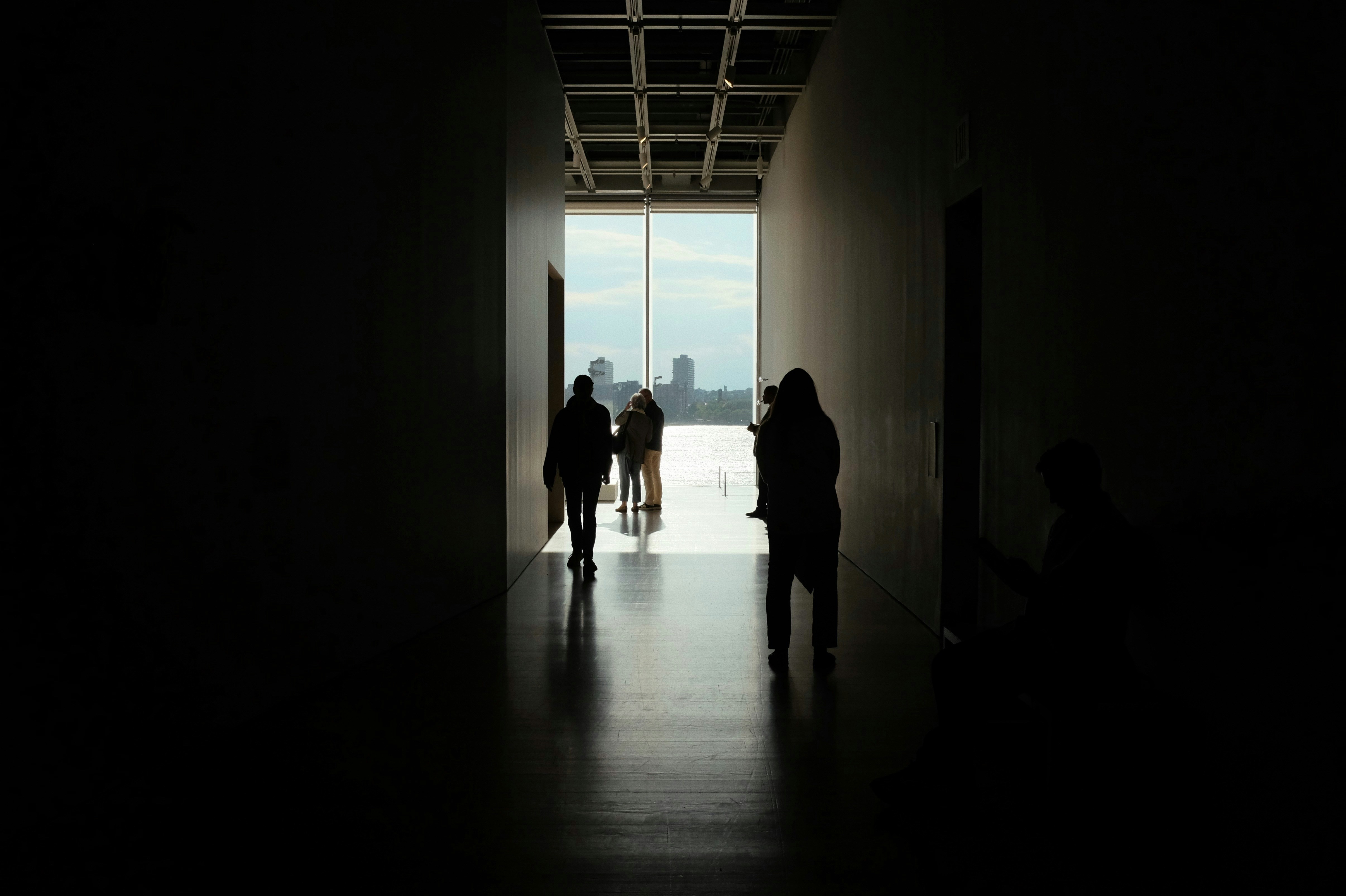 Light at the End of the Hall: silhouettes against city window