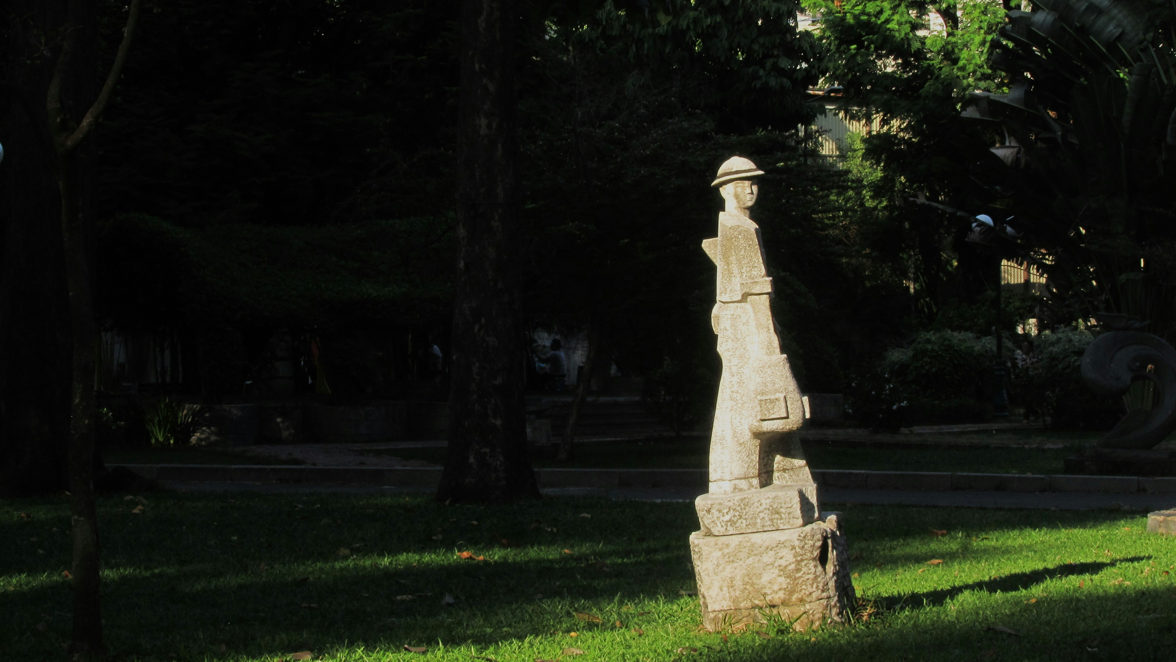 Stone Statue in Dappled Park Light
