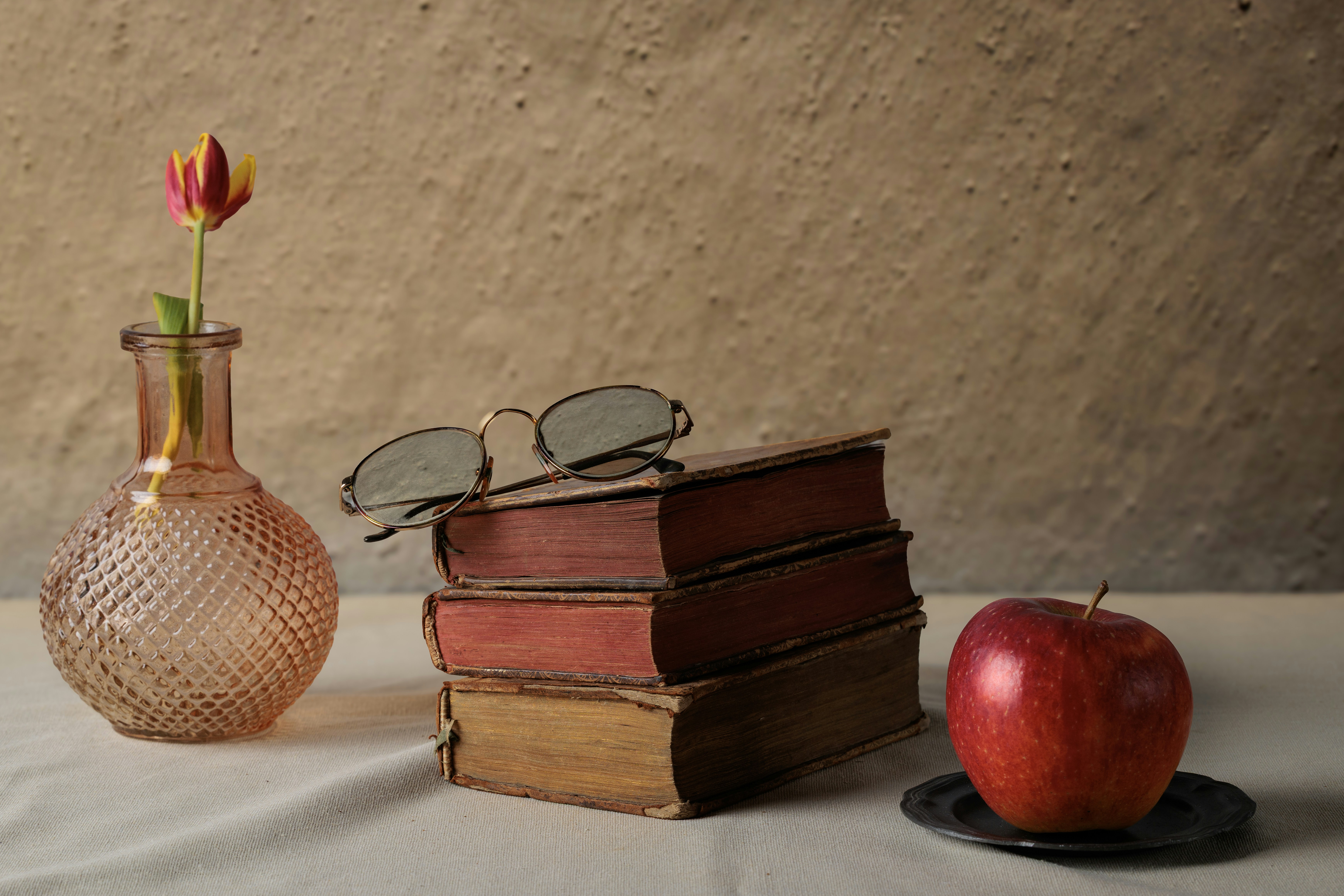 Quiet Study Shelf: Glass Vase, Glasses, and Apple