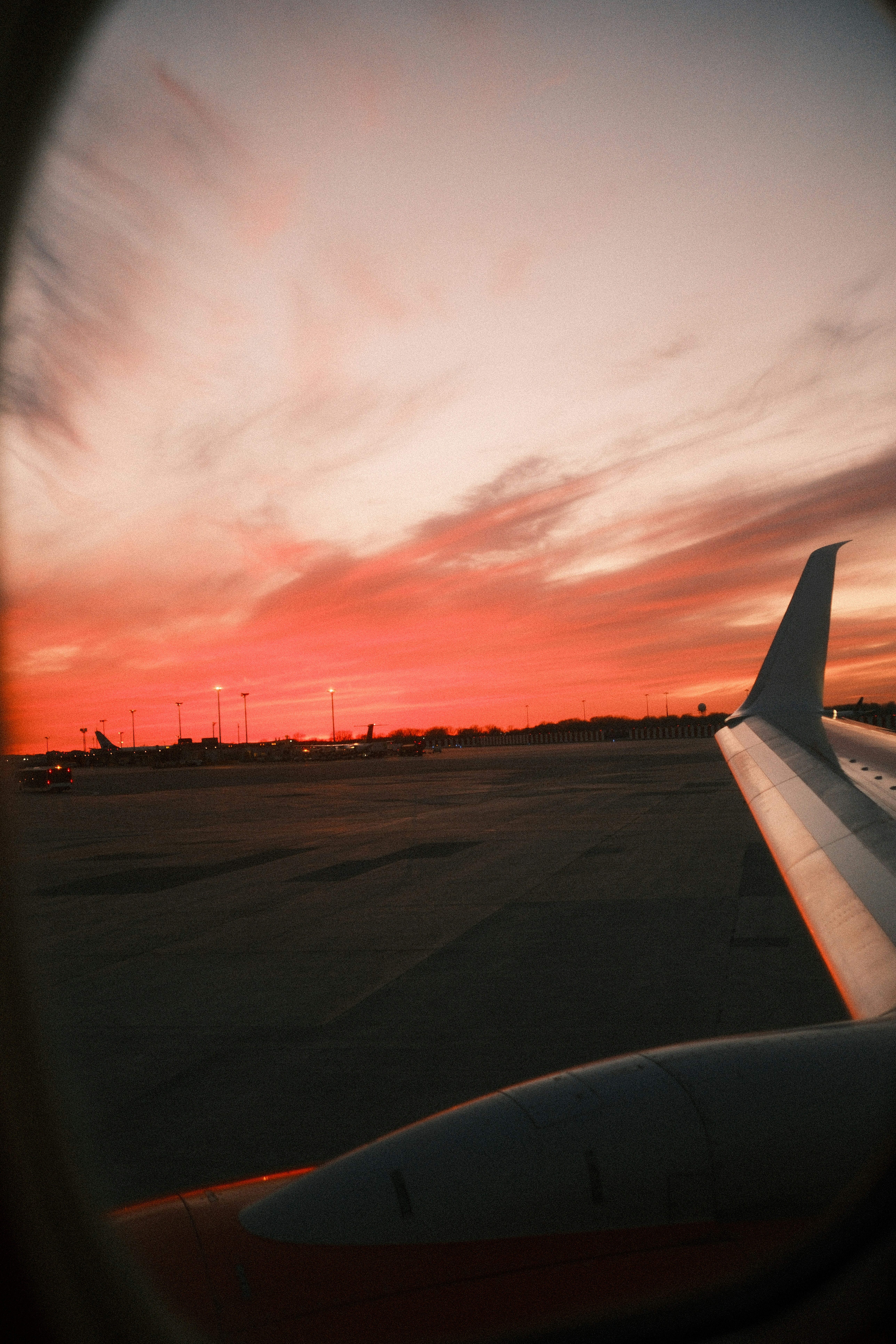 Sunset Window: Wing, Sky, and Runway at Dusk