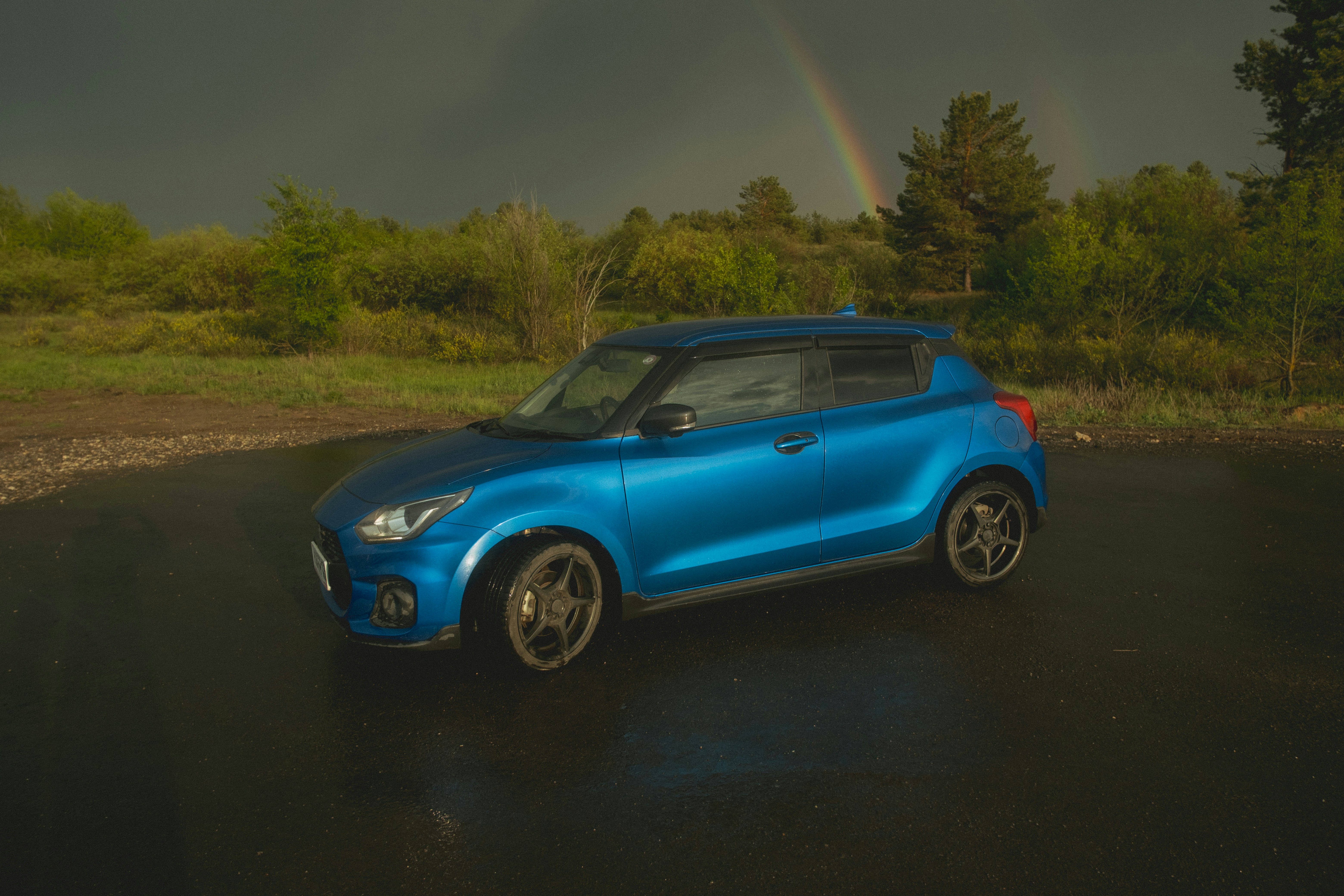 Blue micro-hatch under rainbow: a lone ride after the downpour