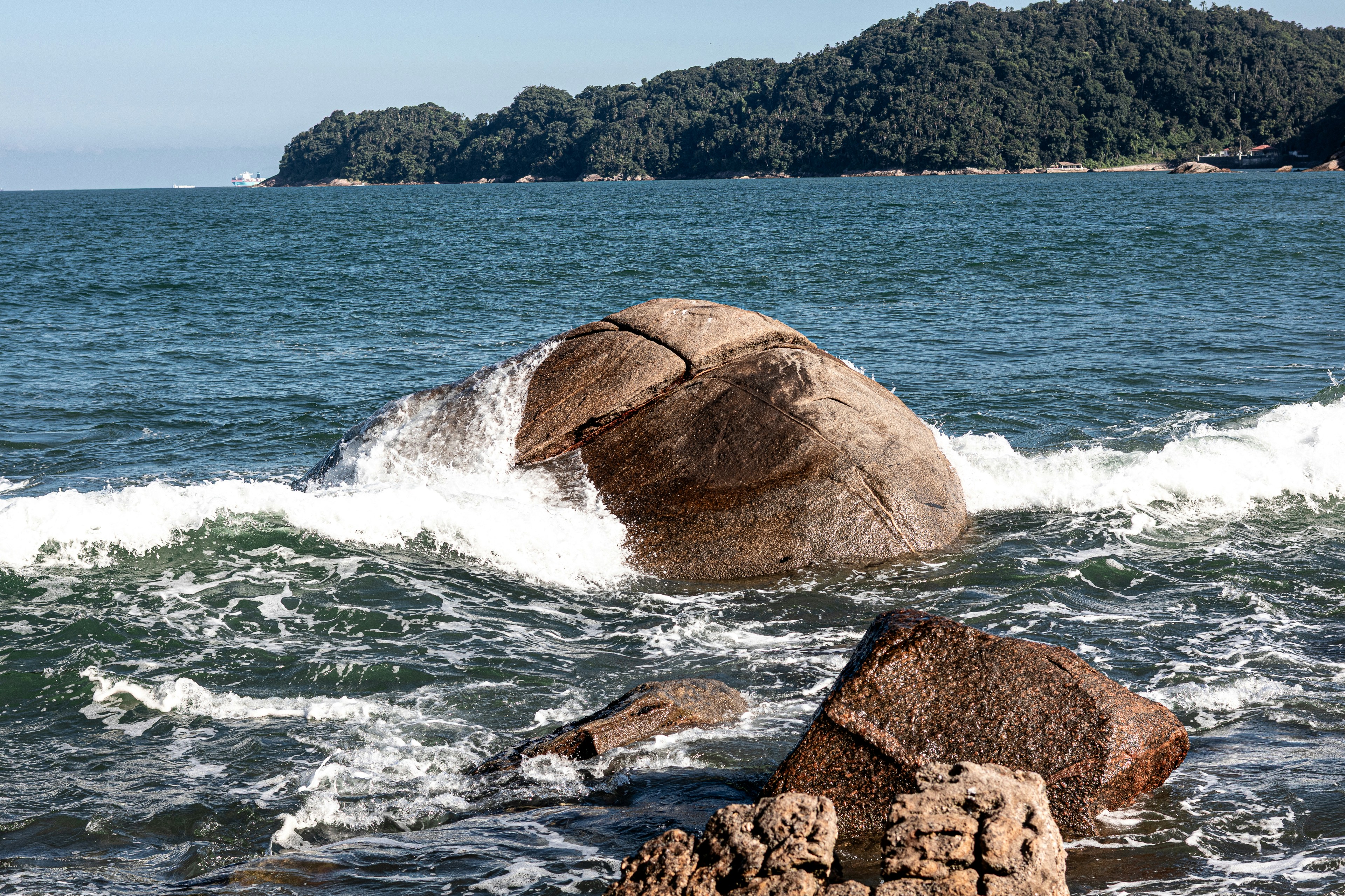 Ocean Sentinel: A Weathered Boulder Breaking the Surf