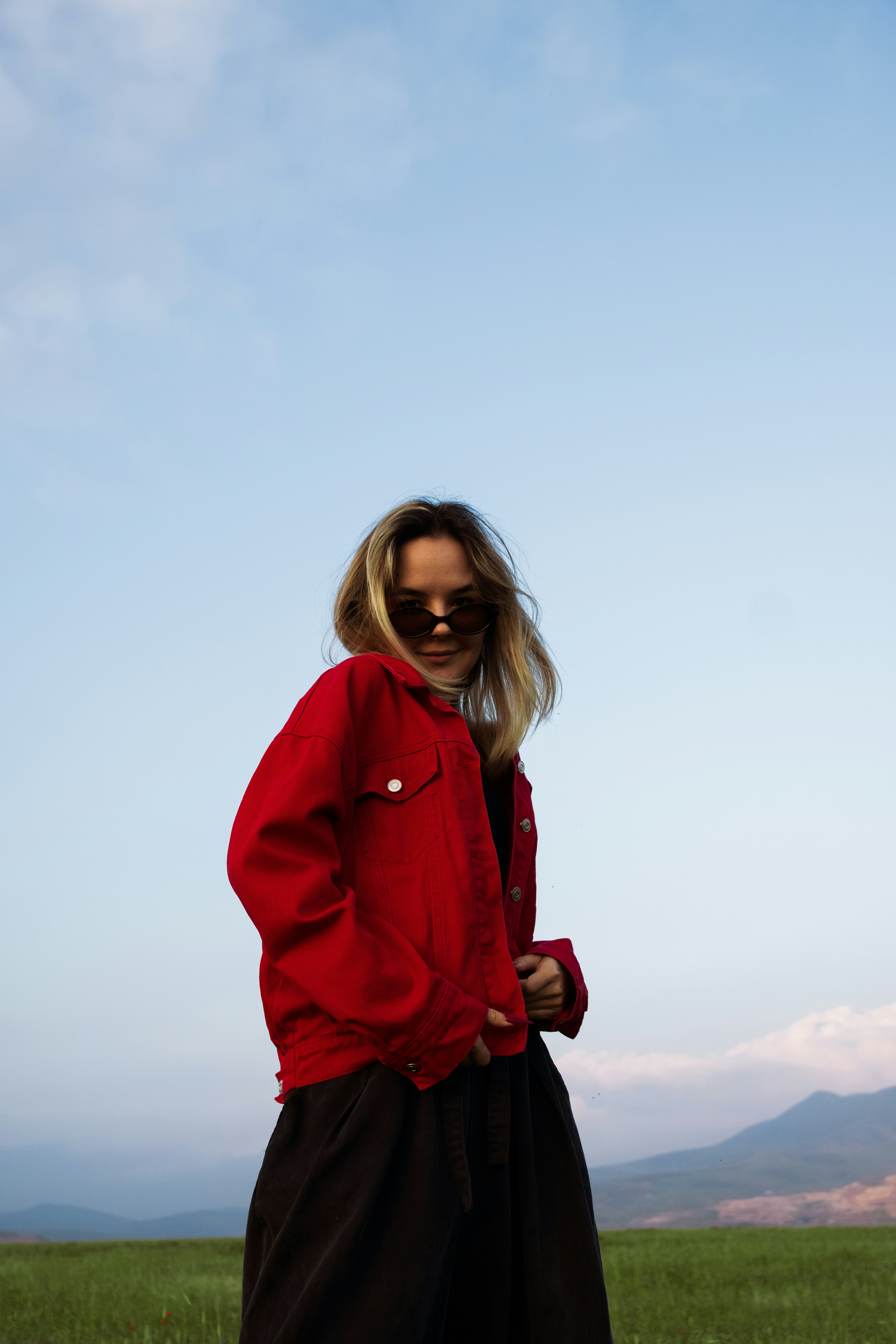 Red Denim Echo: A Confident Portrait Against Open Skies
