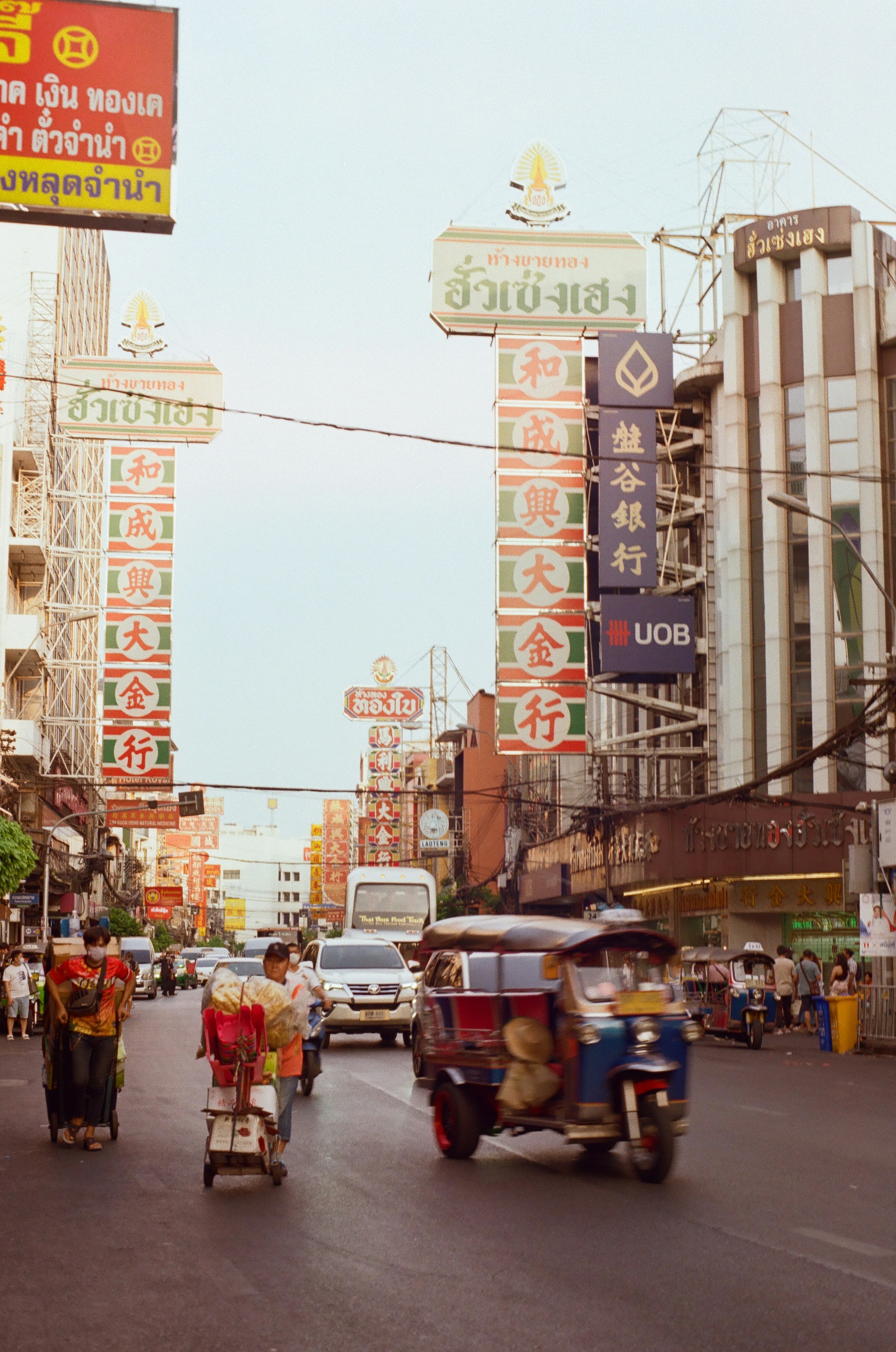 Bustling Bangkok Street: Signs, Trams, and People in Motion