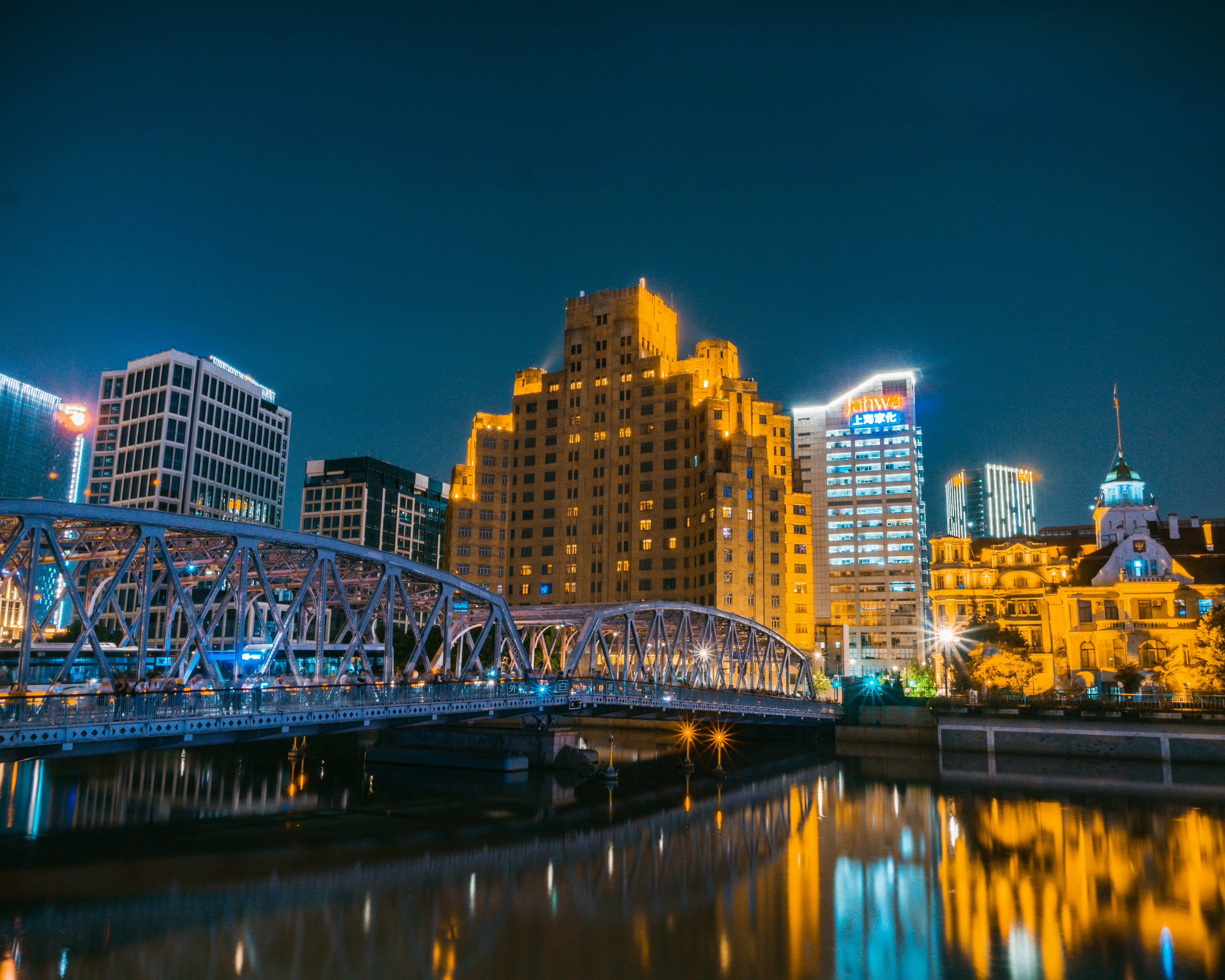 Golden Riverfront Arc: Nighttime City Lights on the Bridge