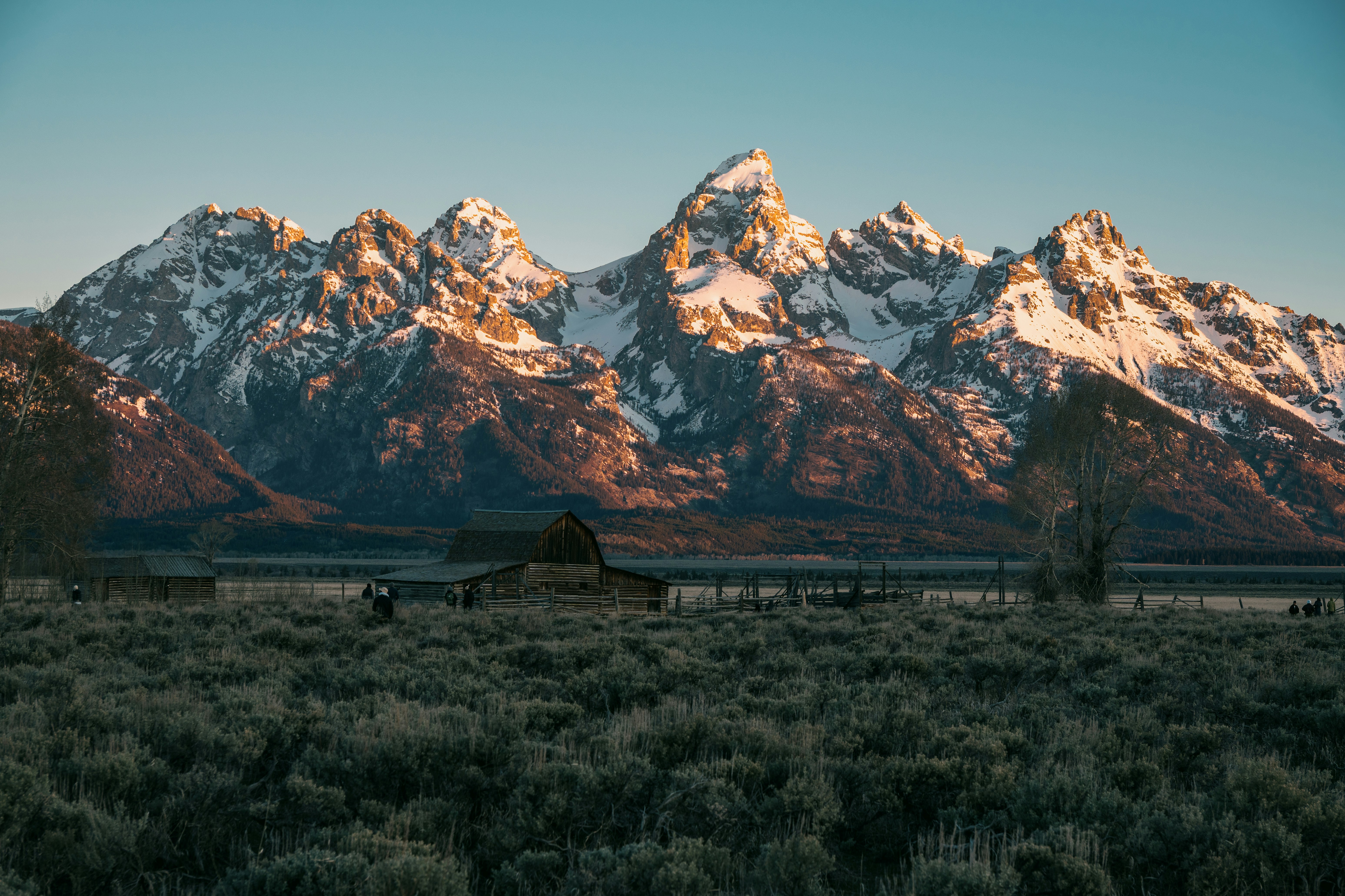 Golden Crest: Snow-Tipped Peaks Over a Quiet Valley Farm