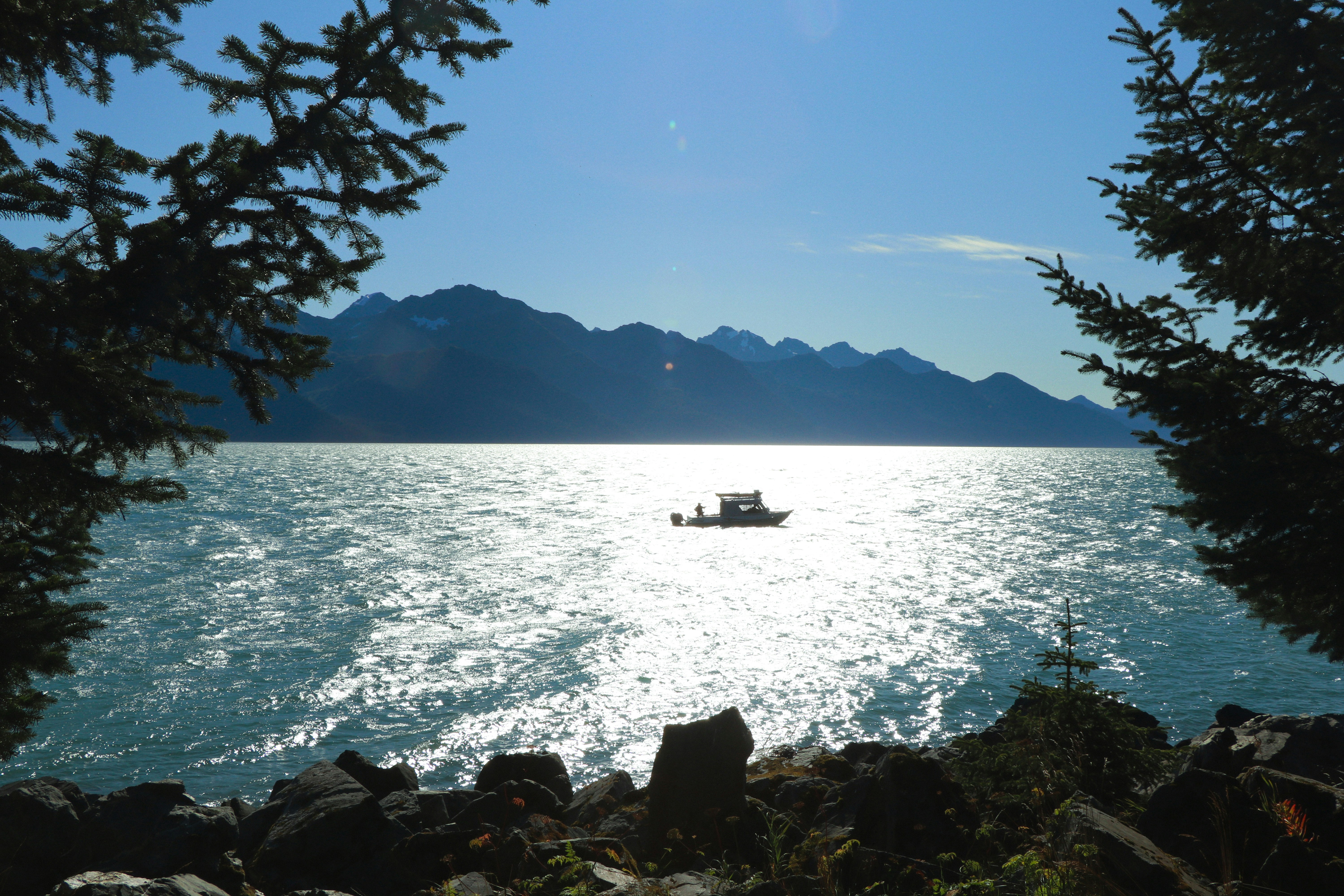 Glinting Lake Under Mountain Shade with a Lone Boat