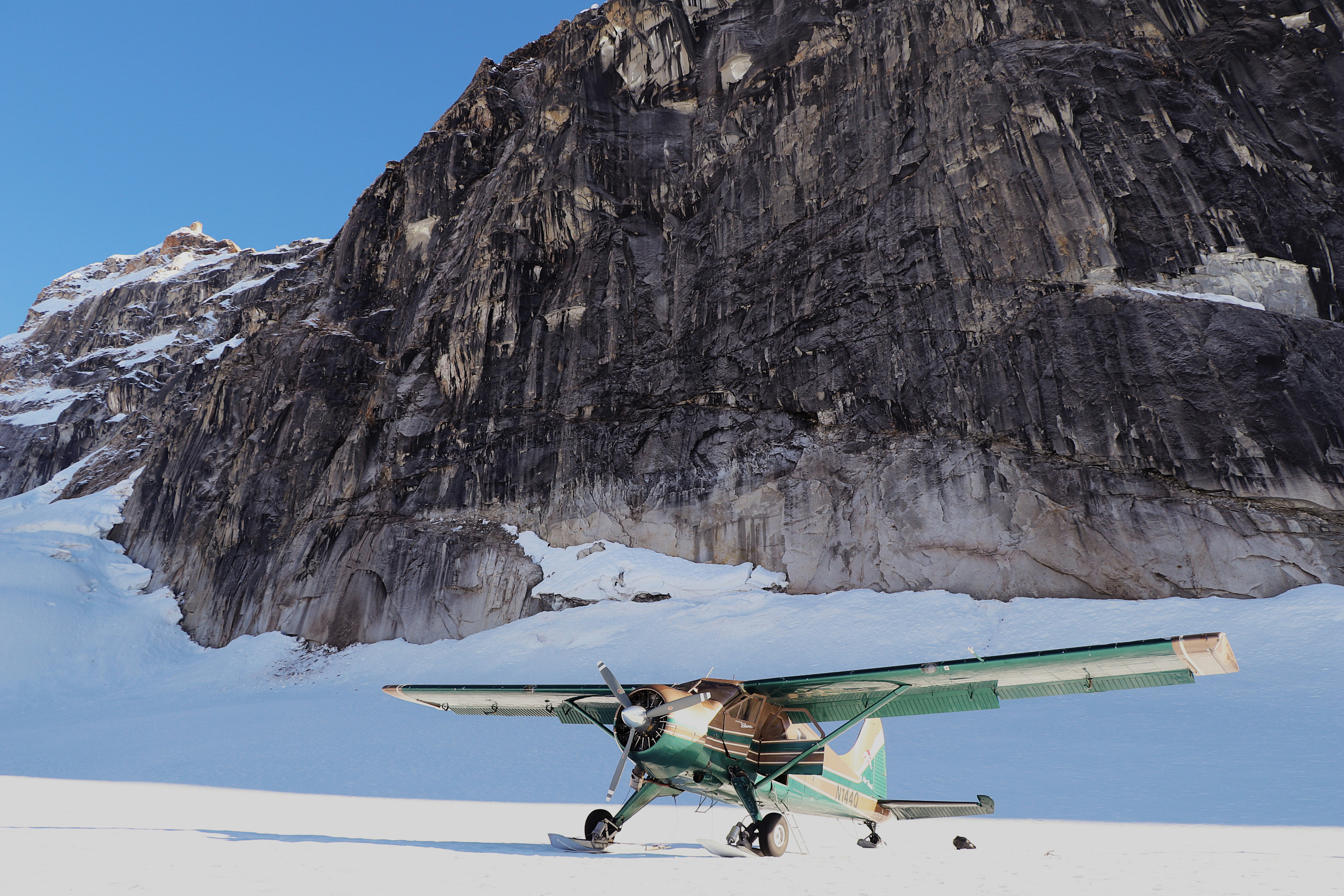 Snowbound Skydiver: A Vintage Plane Tucked Against a Frozen Cliff