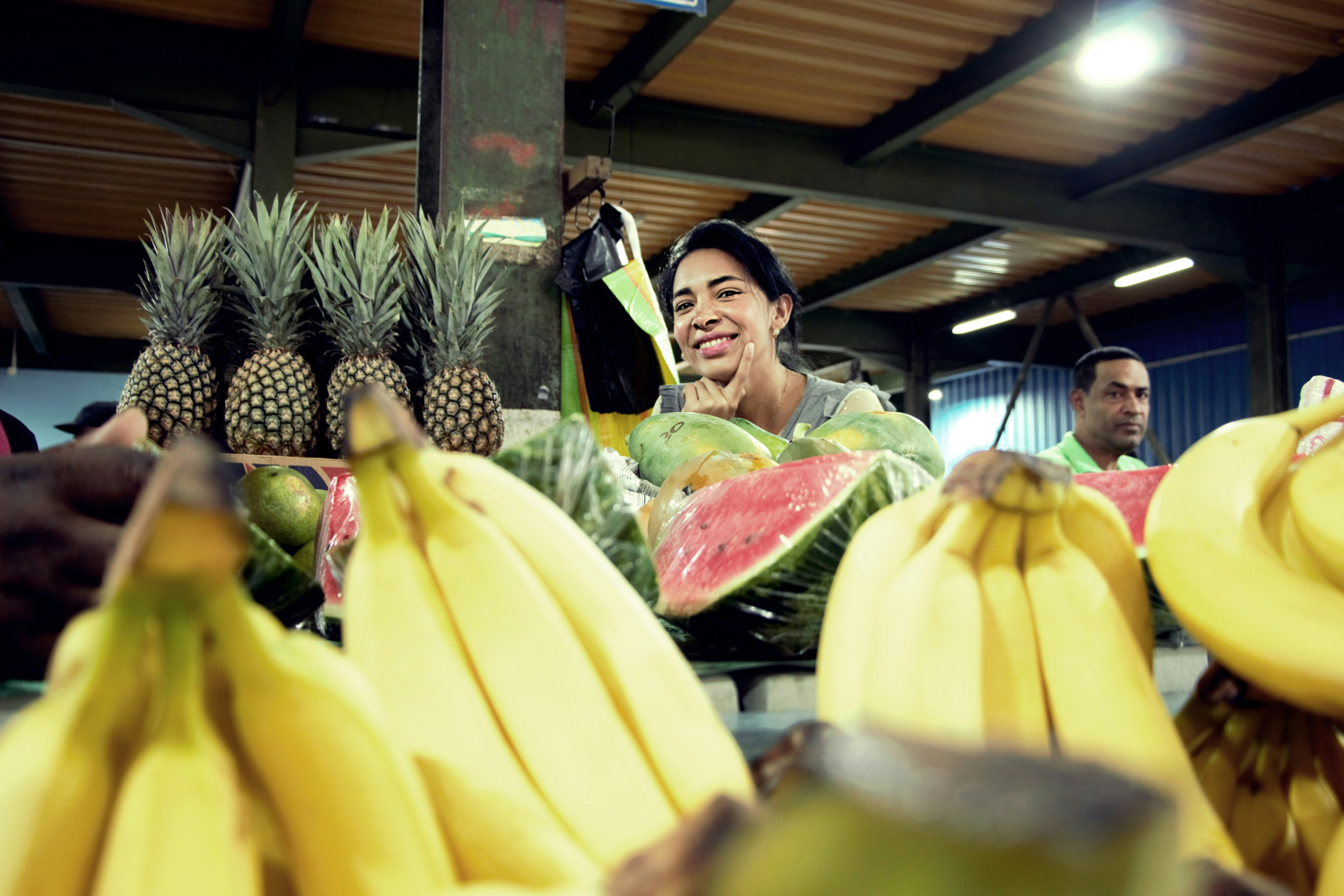 Market Stall Smile: Fruit Fresco Behind a Blur of Bananas