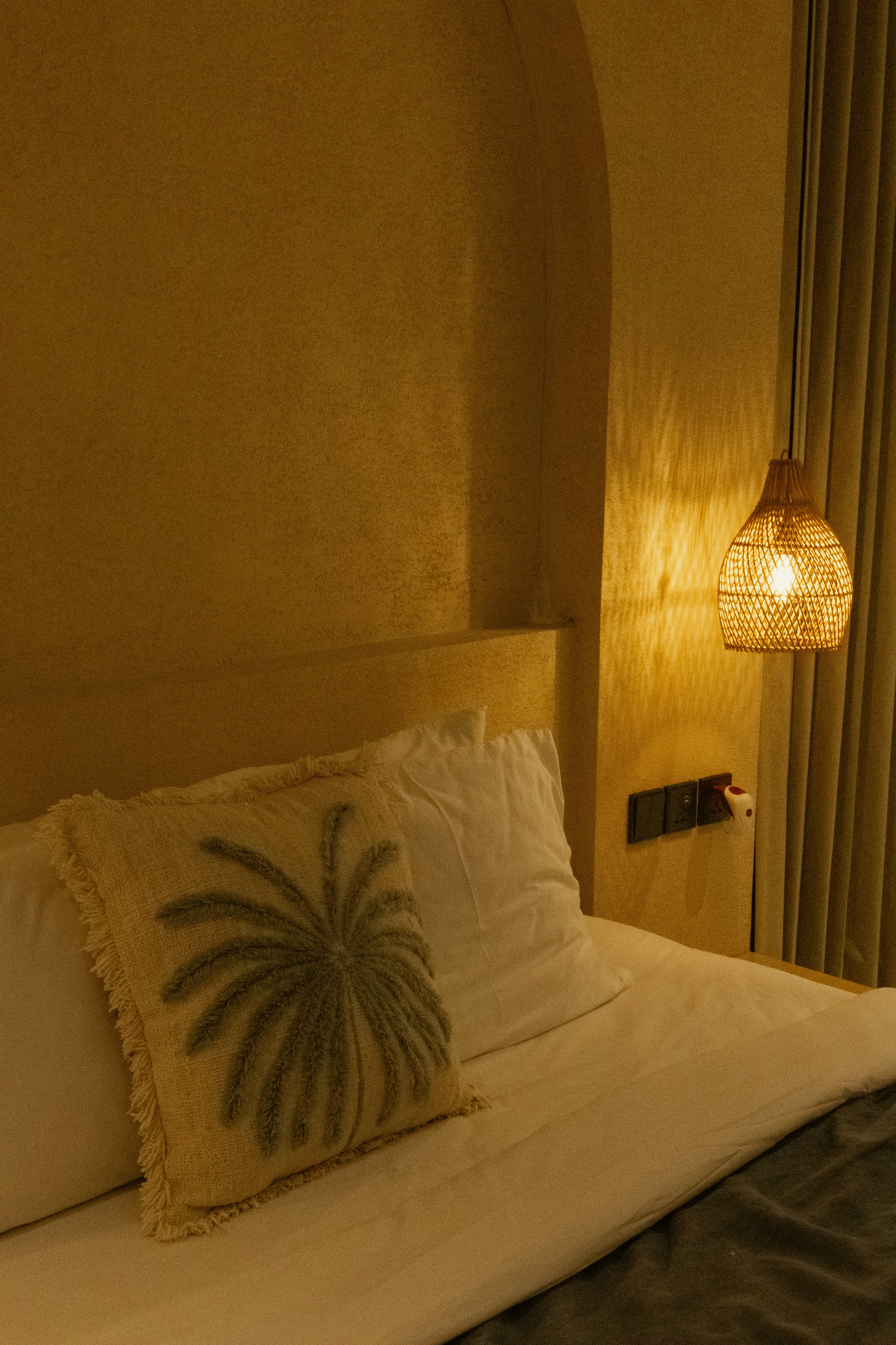 Warm Hotel Nightscape: Cushioned Bed and Rattan Lamp Glow